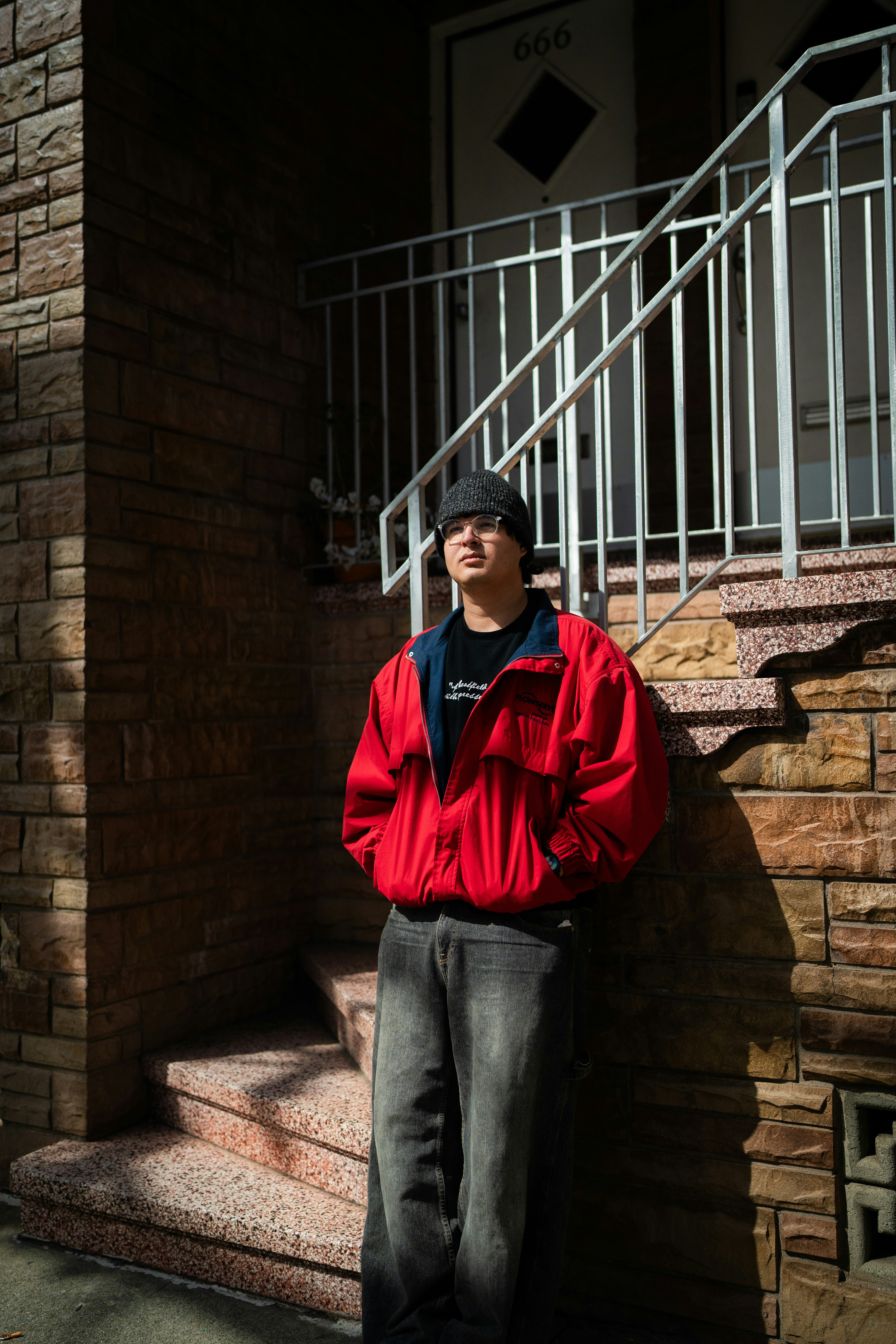 A man stands beside a building's steps. photo – Free Fashion Image on ...