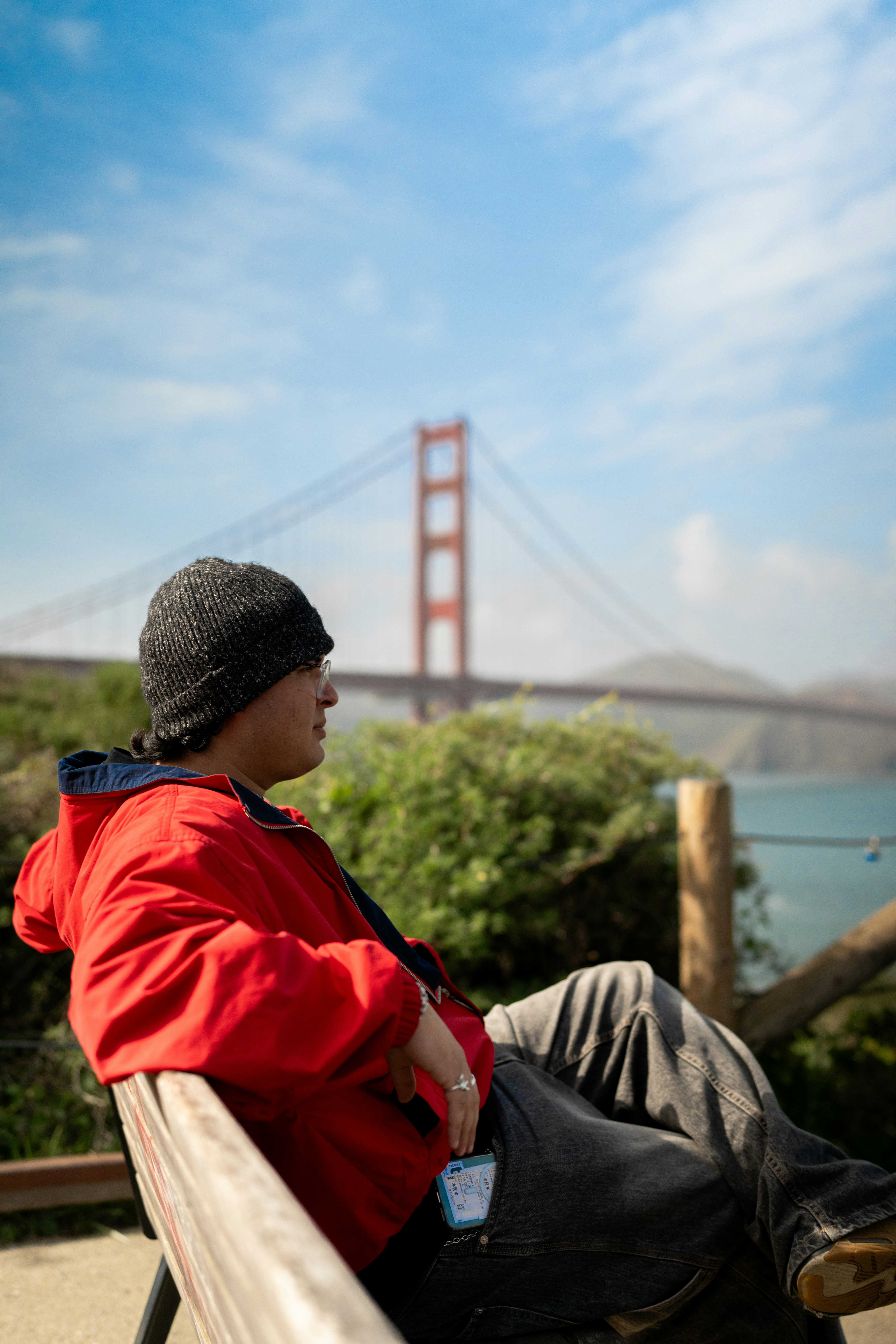 Red Jacket, Blue Skies: A Quiet Moment with the Golden Gate in the Background