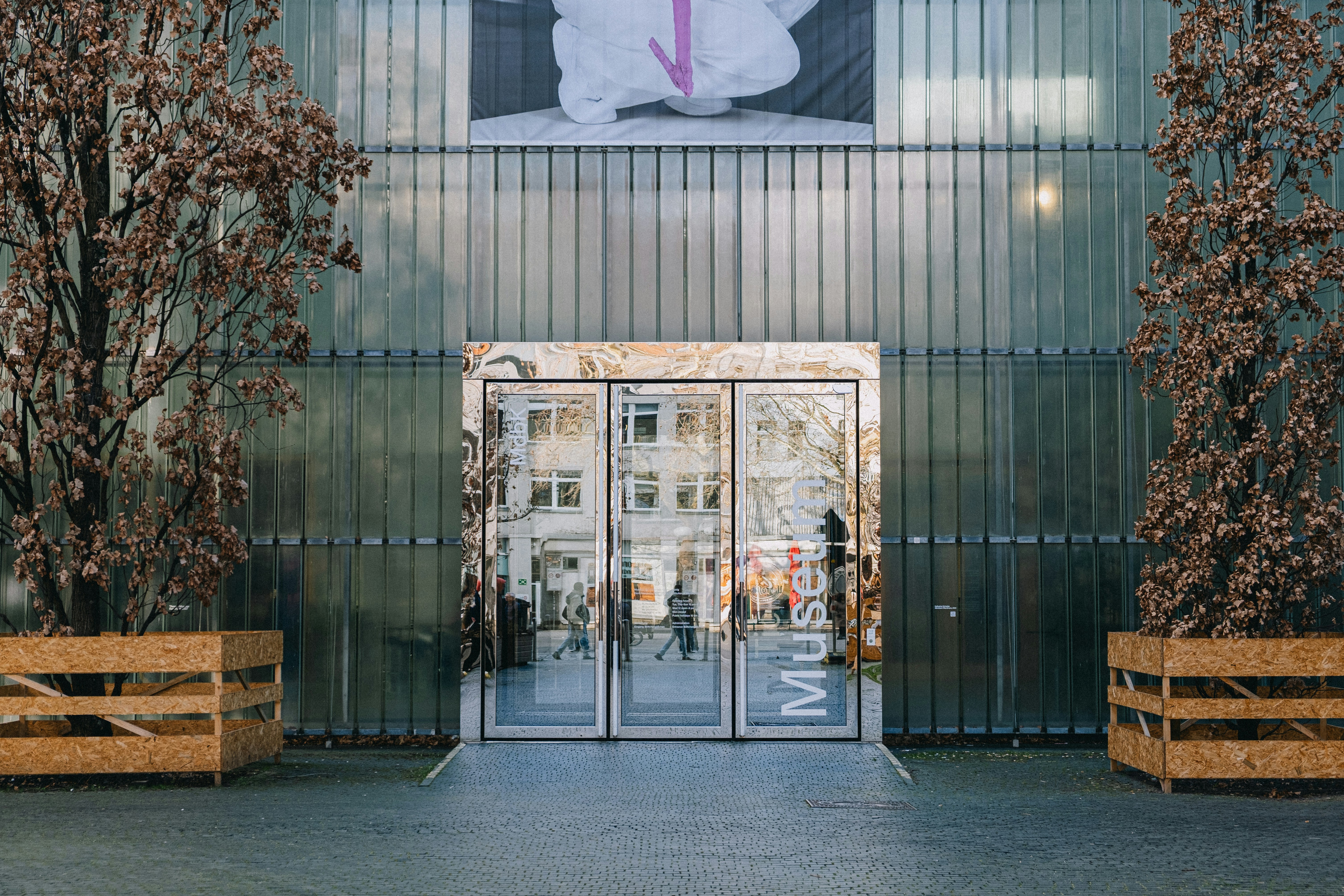 Entrée de musée moderne avec portes vitrées et arbres. photo – Image ...