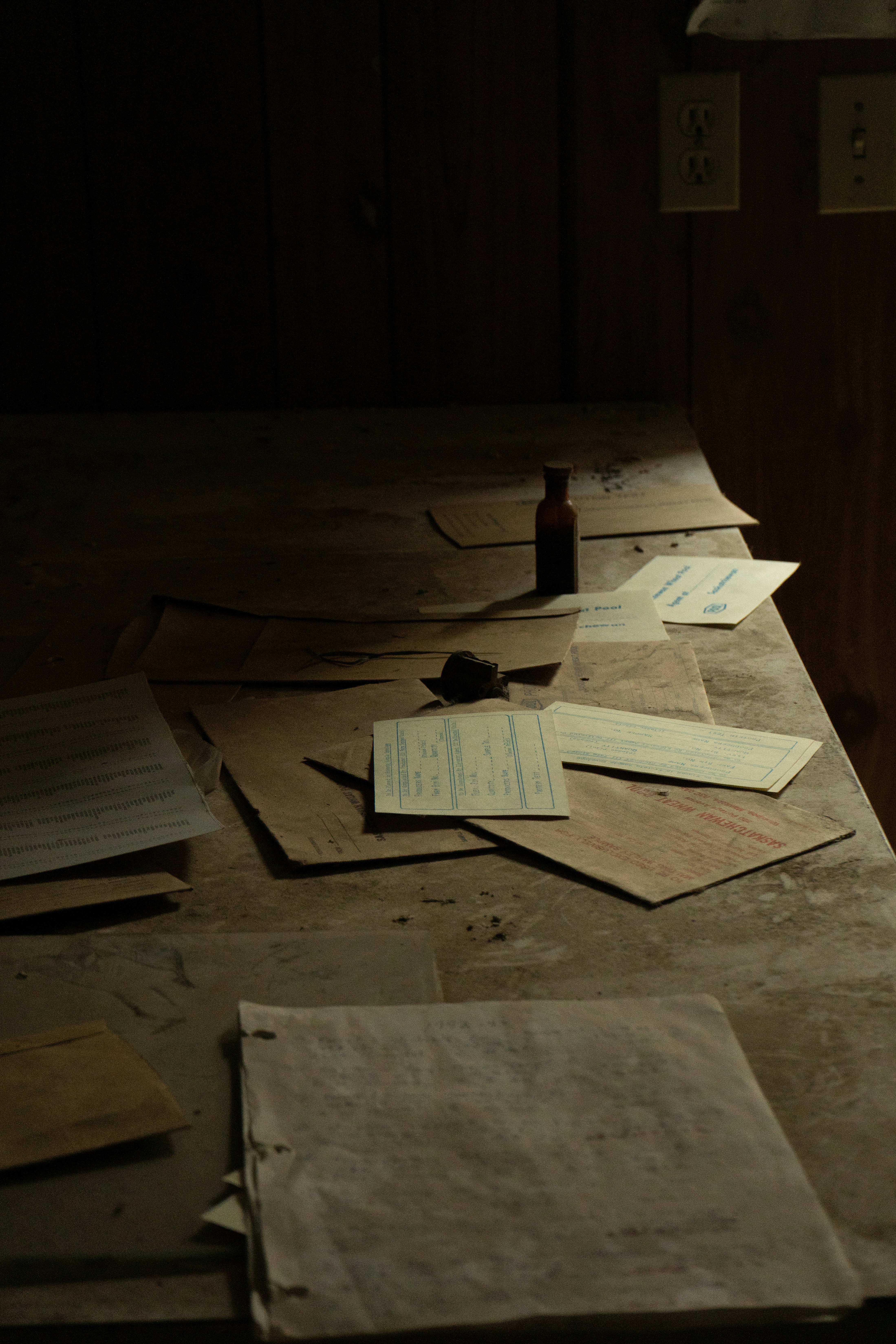 Papers and a small bottle rest on a dusty table. photo – Free Office ...