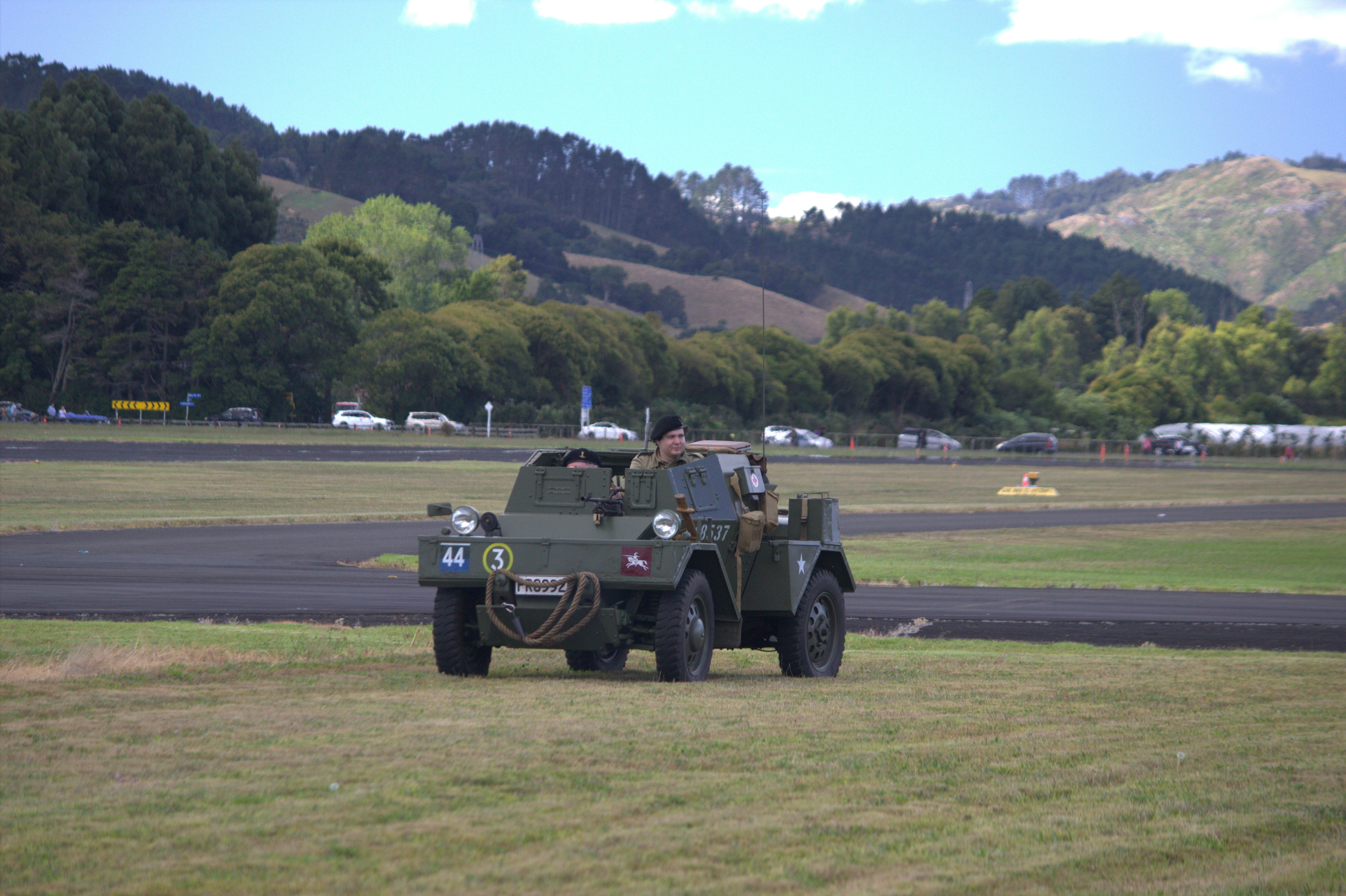 A military vehicle drives on a grassy field. photo – Free Car Image on ...