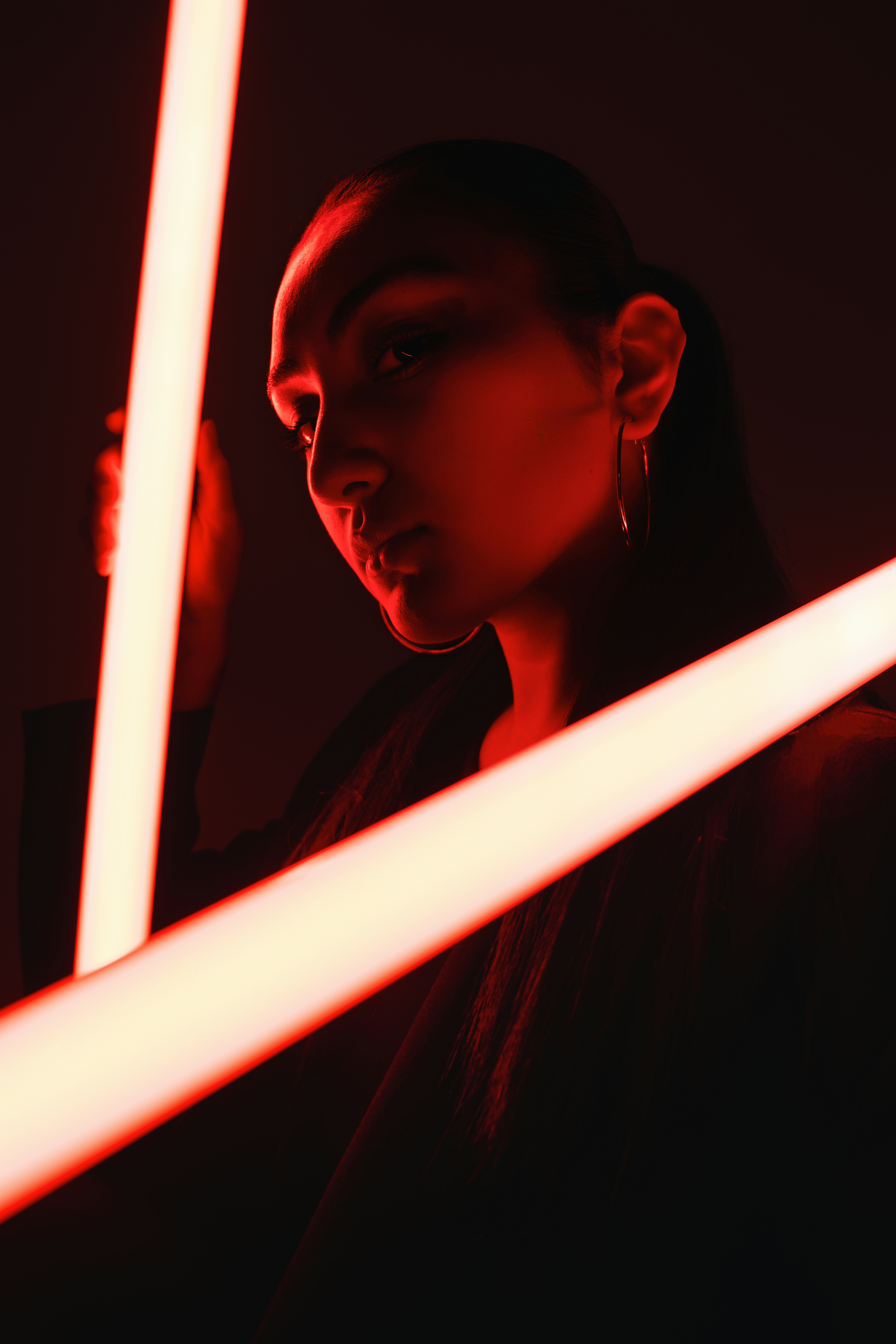 A woman poses with red lightsabers. photo – Free Portrait Image on Unsplash