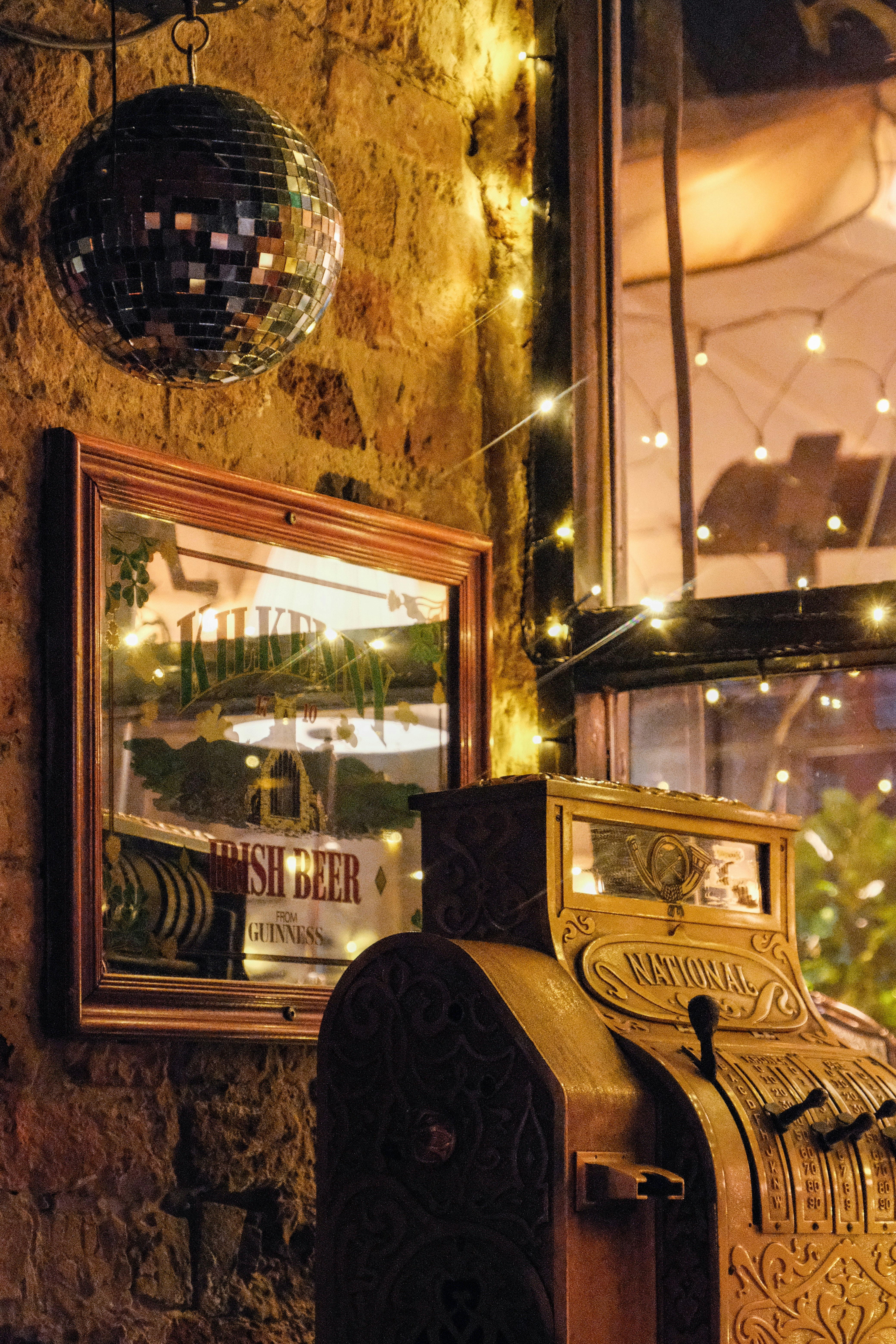 Copper Glow in a Stone-Walled Bar: Fairy Lights, a Vintage Cash Register, and a Disco Ball