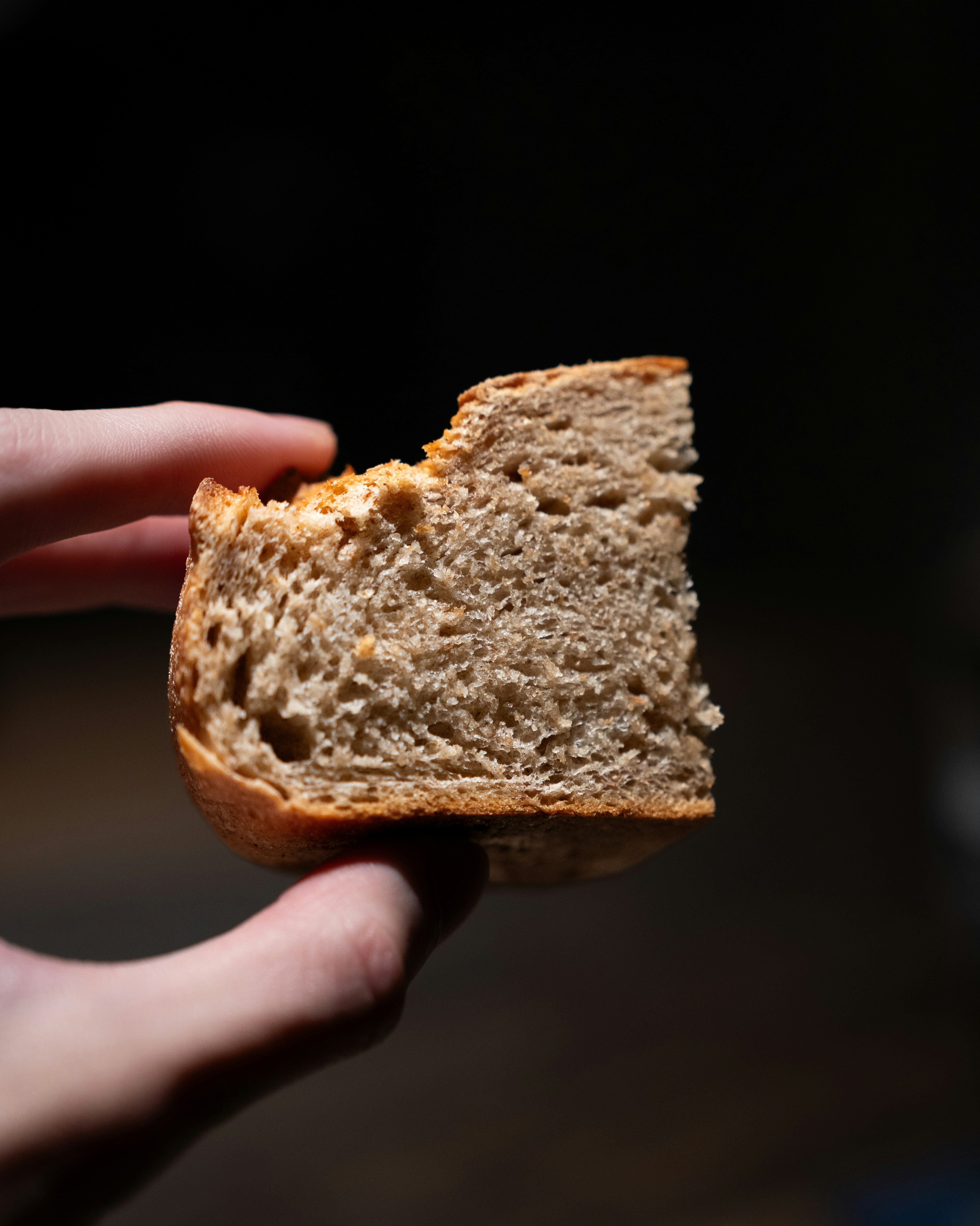 La main tenant une tranche de pain fraîchement cuit. photo – Image ...