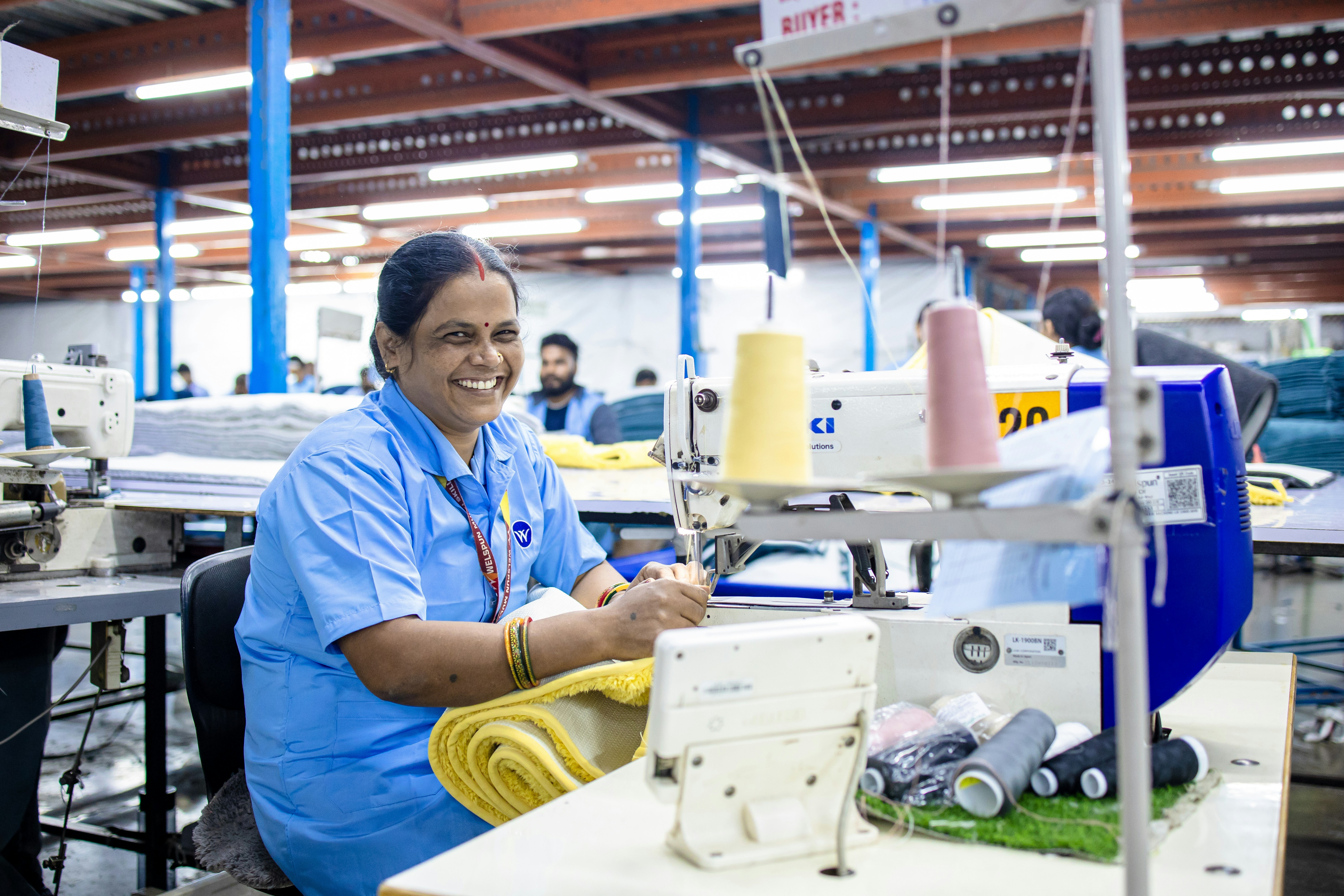 Woman smiles working at a sewing machine. photo – Free Man Image on ...