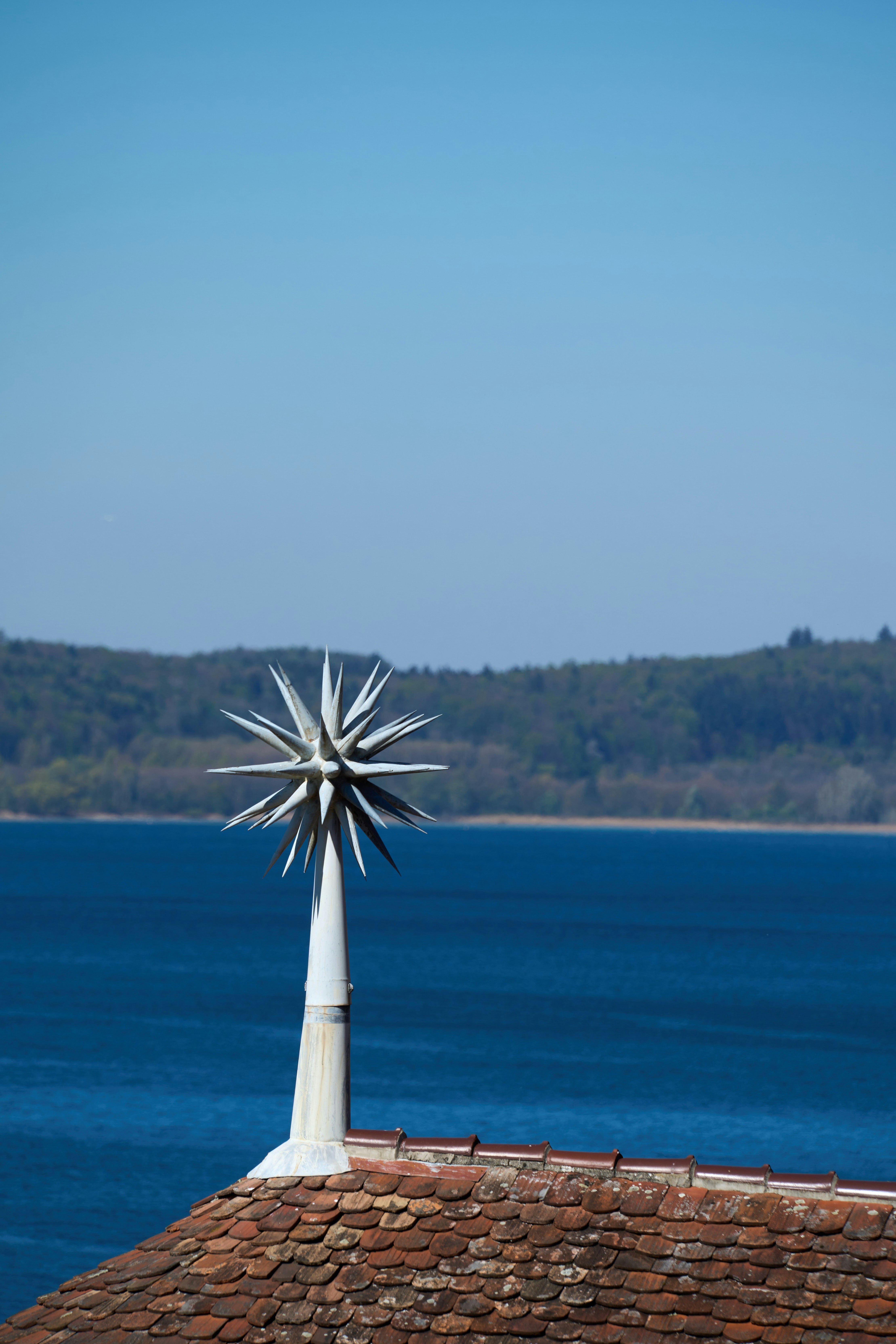 Wind-Star on a Clay Tile Roof Over a Calm Blue Bay