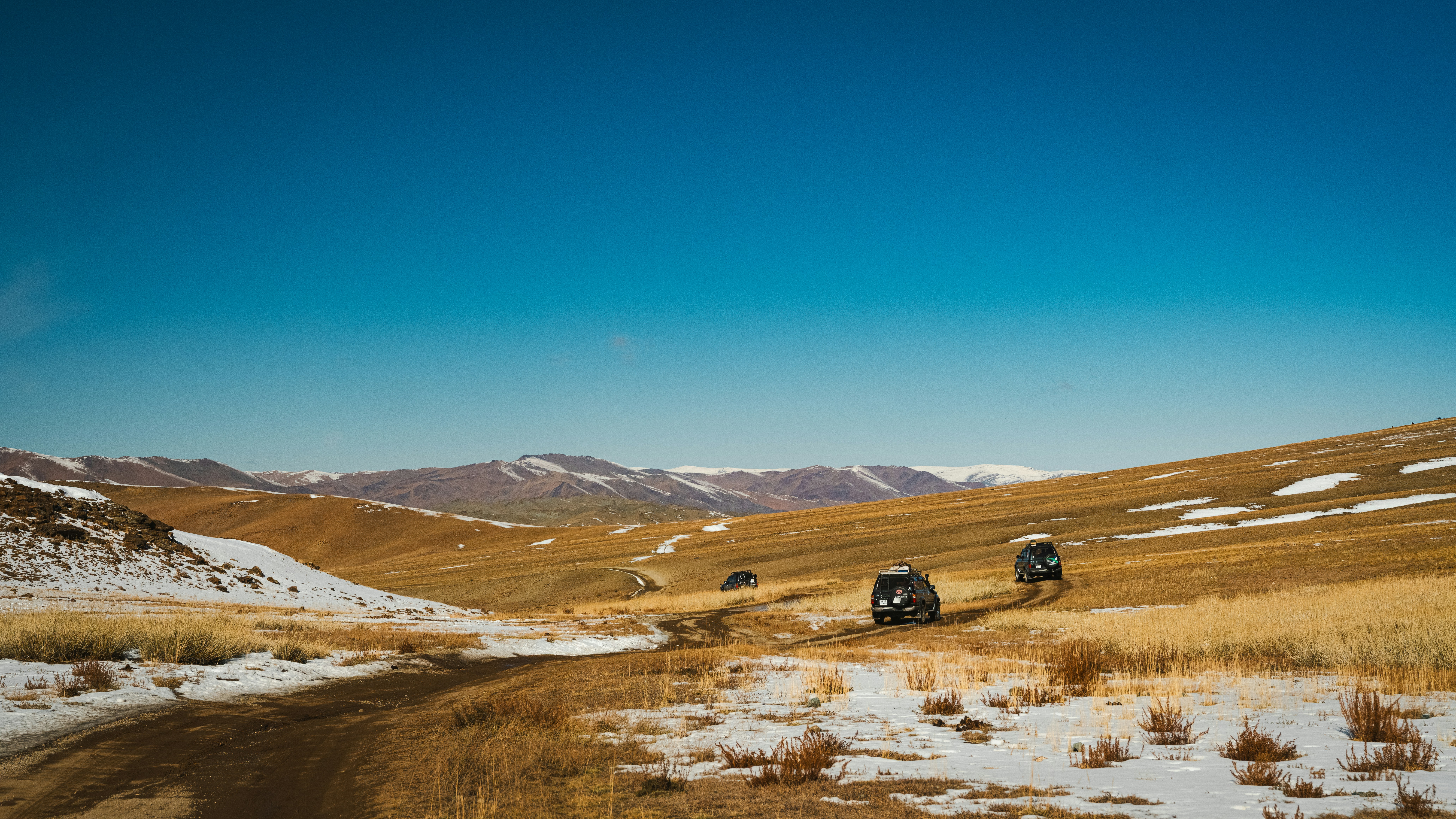 Cars drive on a road through the mountains. photo – Free Car Image on ...