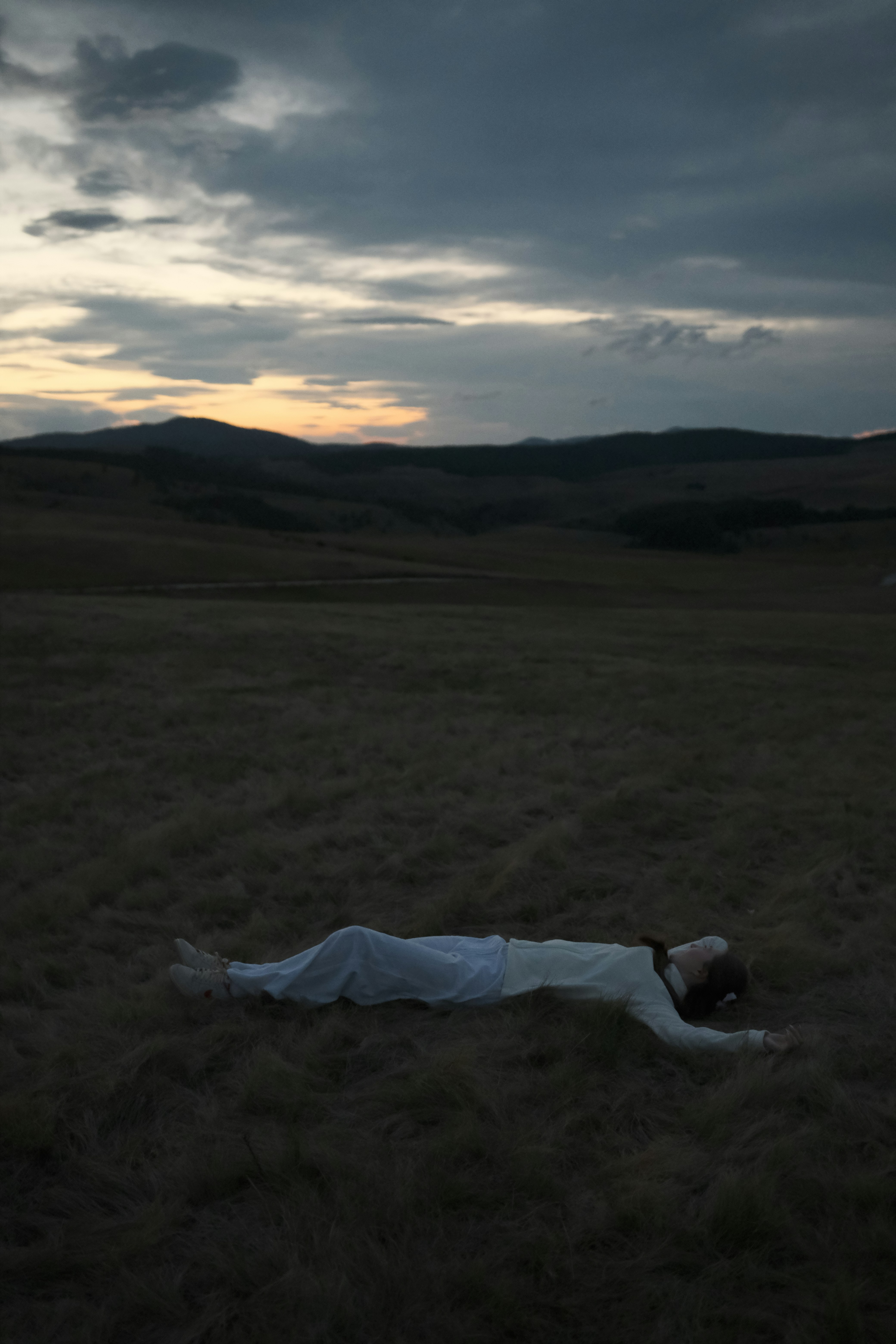 Woman lies in field under a dusky sky. photo – Free Woman Image on Unsplash