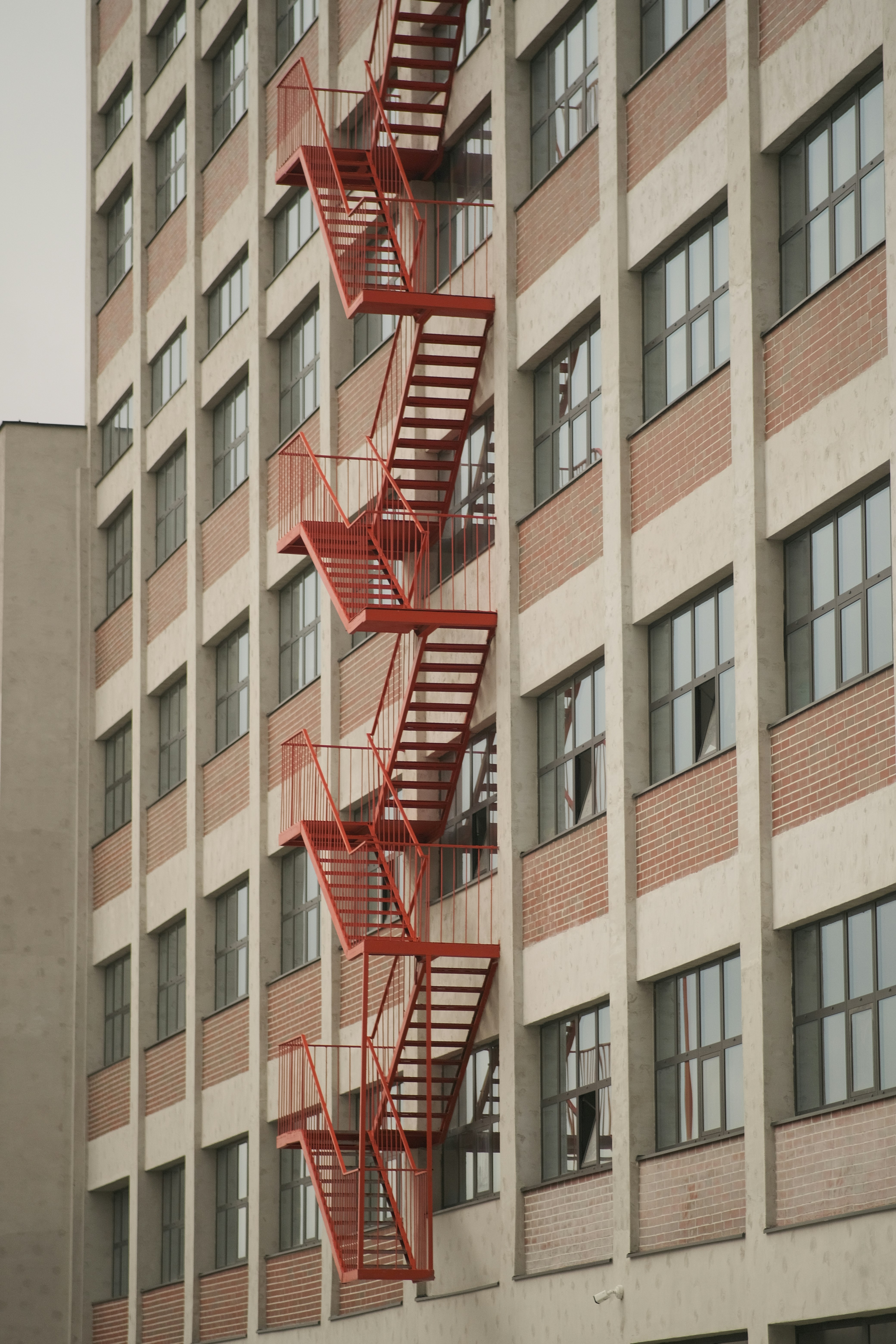 Crimson Staircase Geometry Along the Brick Facade
