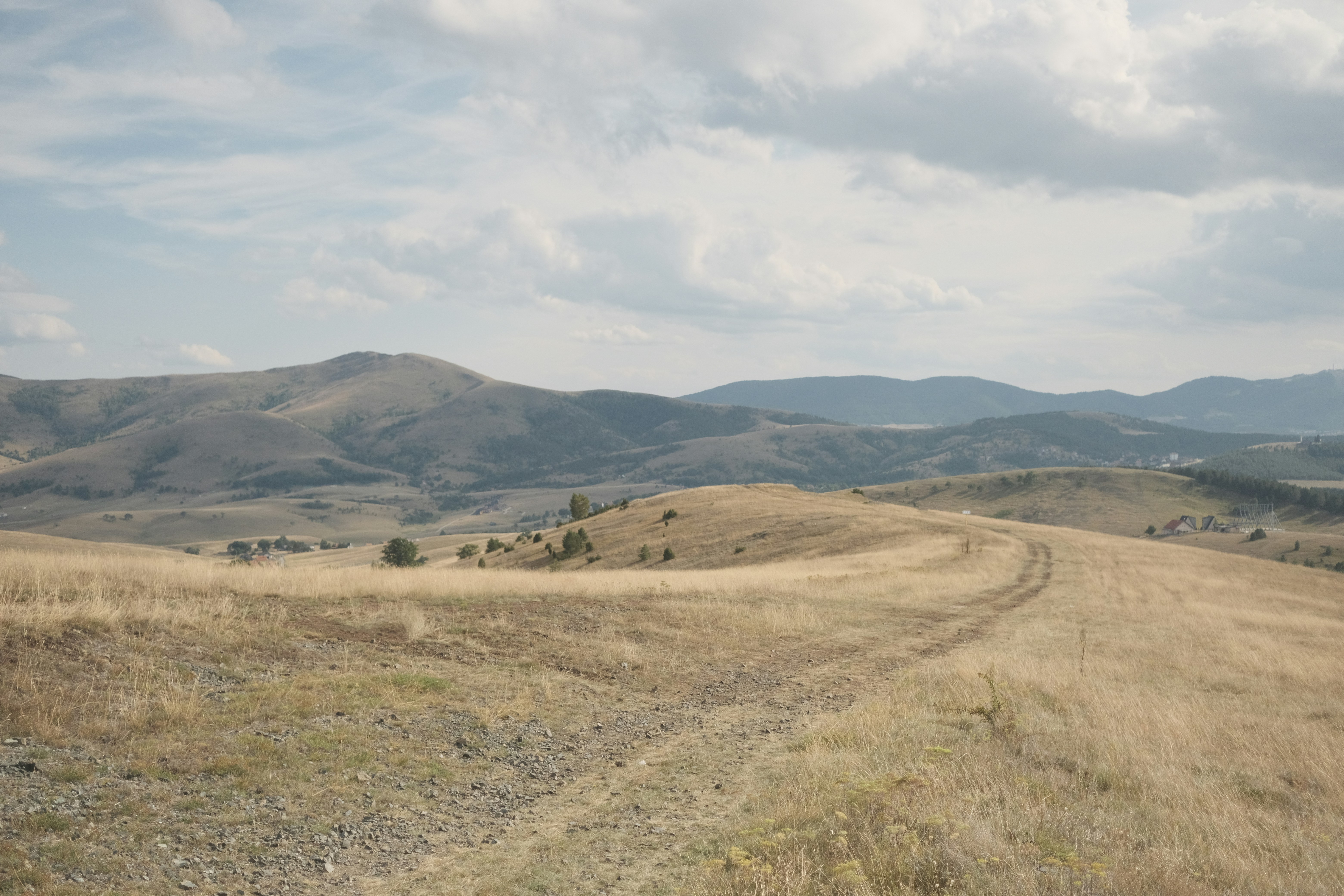 Rolling hills and a trail under a cloudy sky. photo – Free Outdoor ...