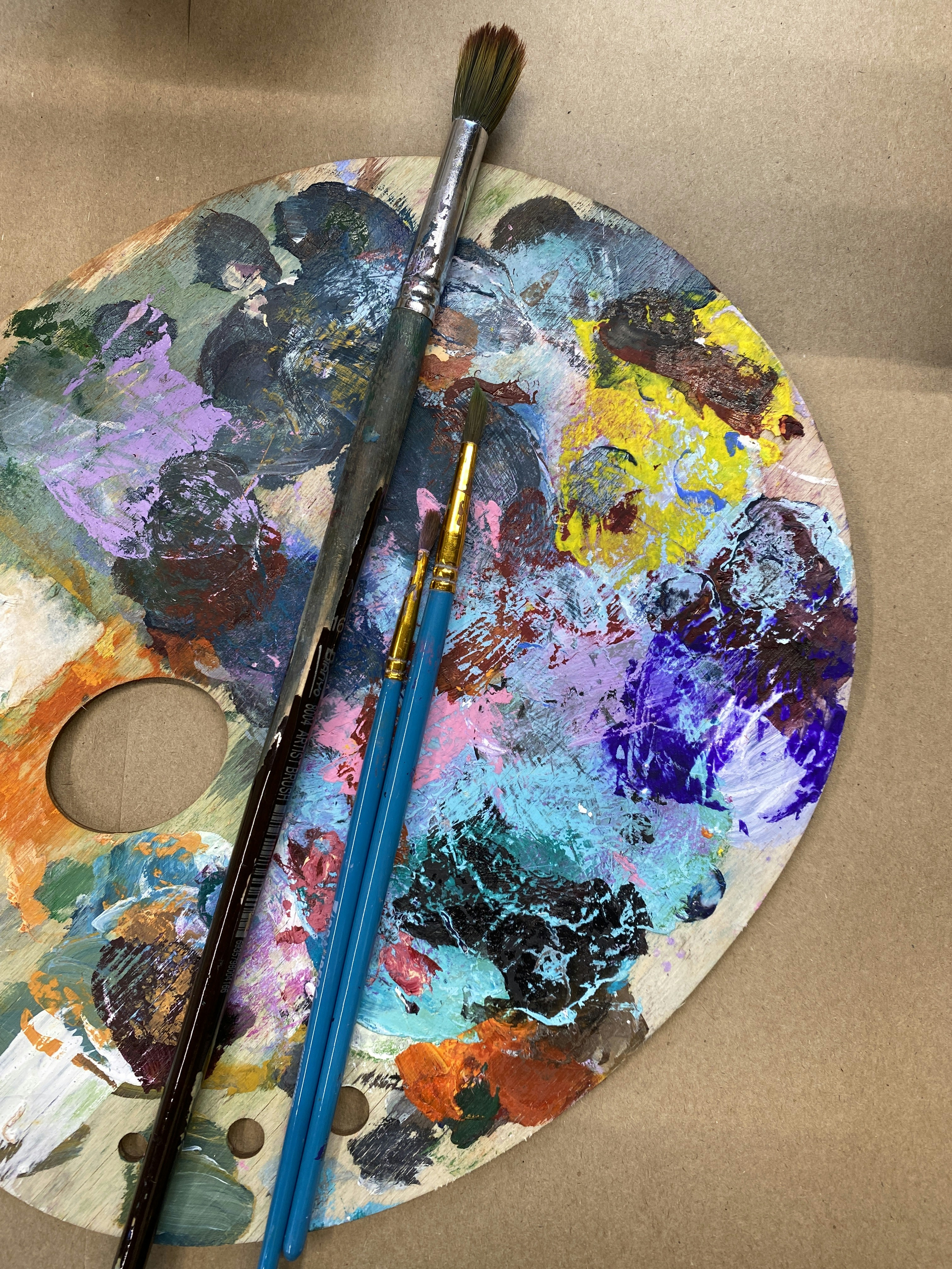 An artist's palette adorned with vibrant splashes of paint, accompanied by brushes ready for creativity.