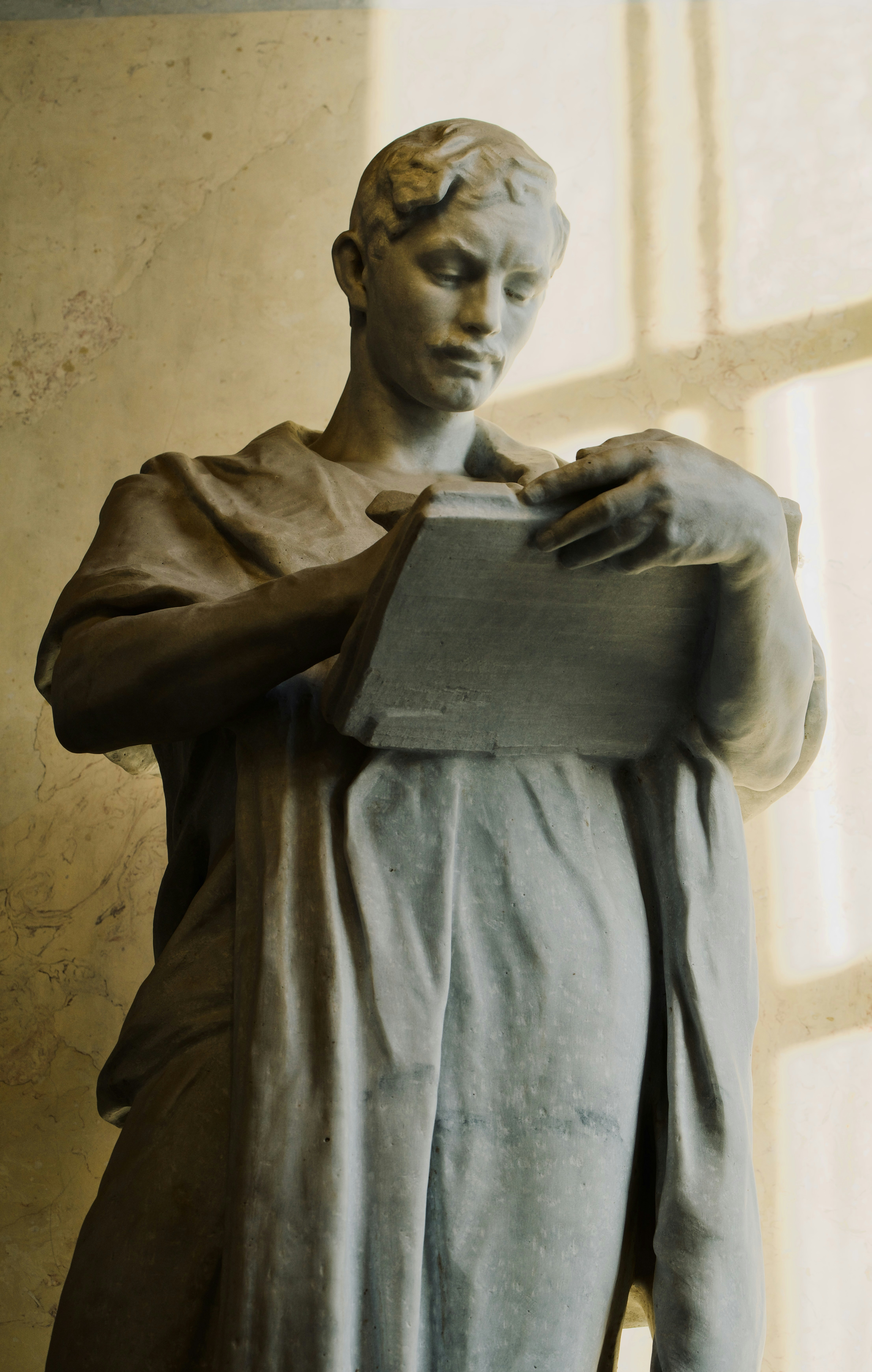 Marble Scholar Pores Over Pages in Soft Sunlit Hall