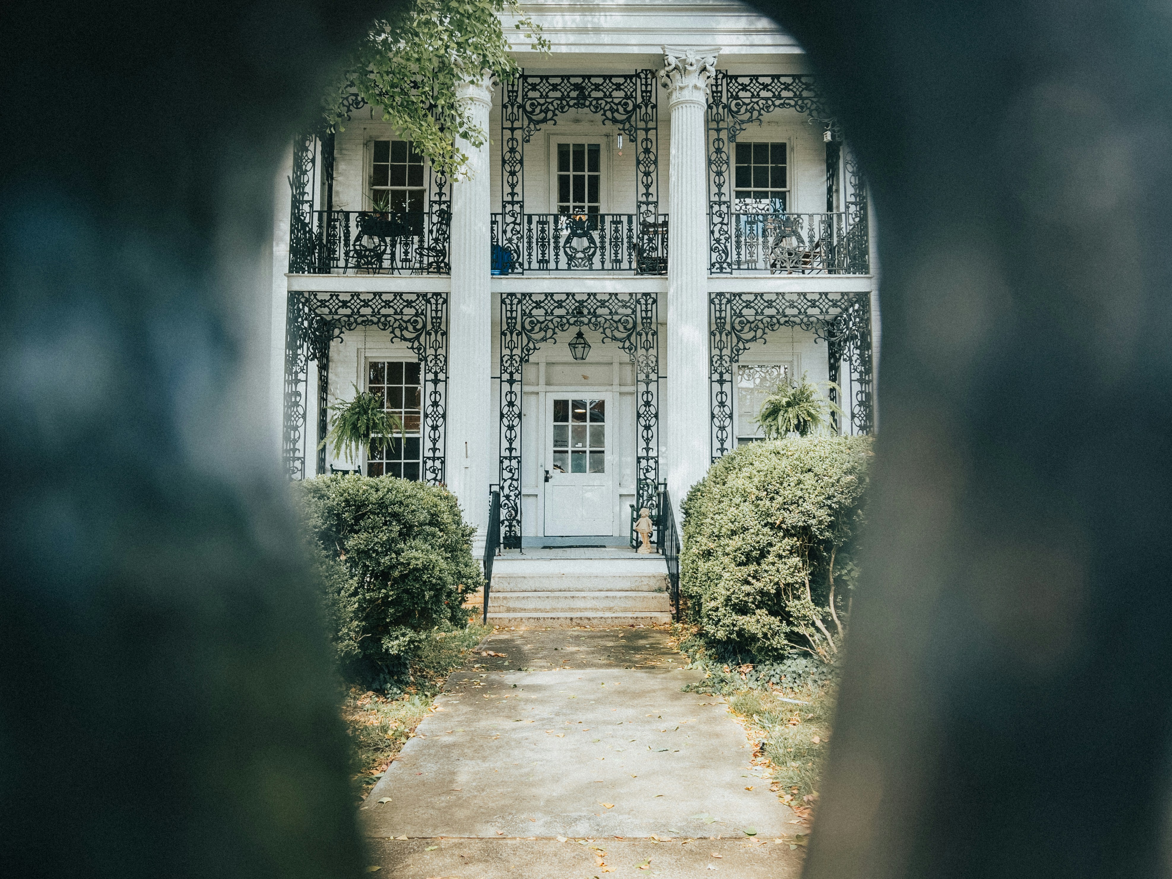 A grand white house is viewed through a keyhole. photo – Free ...