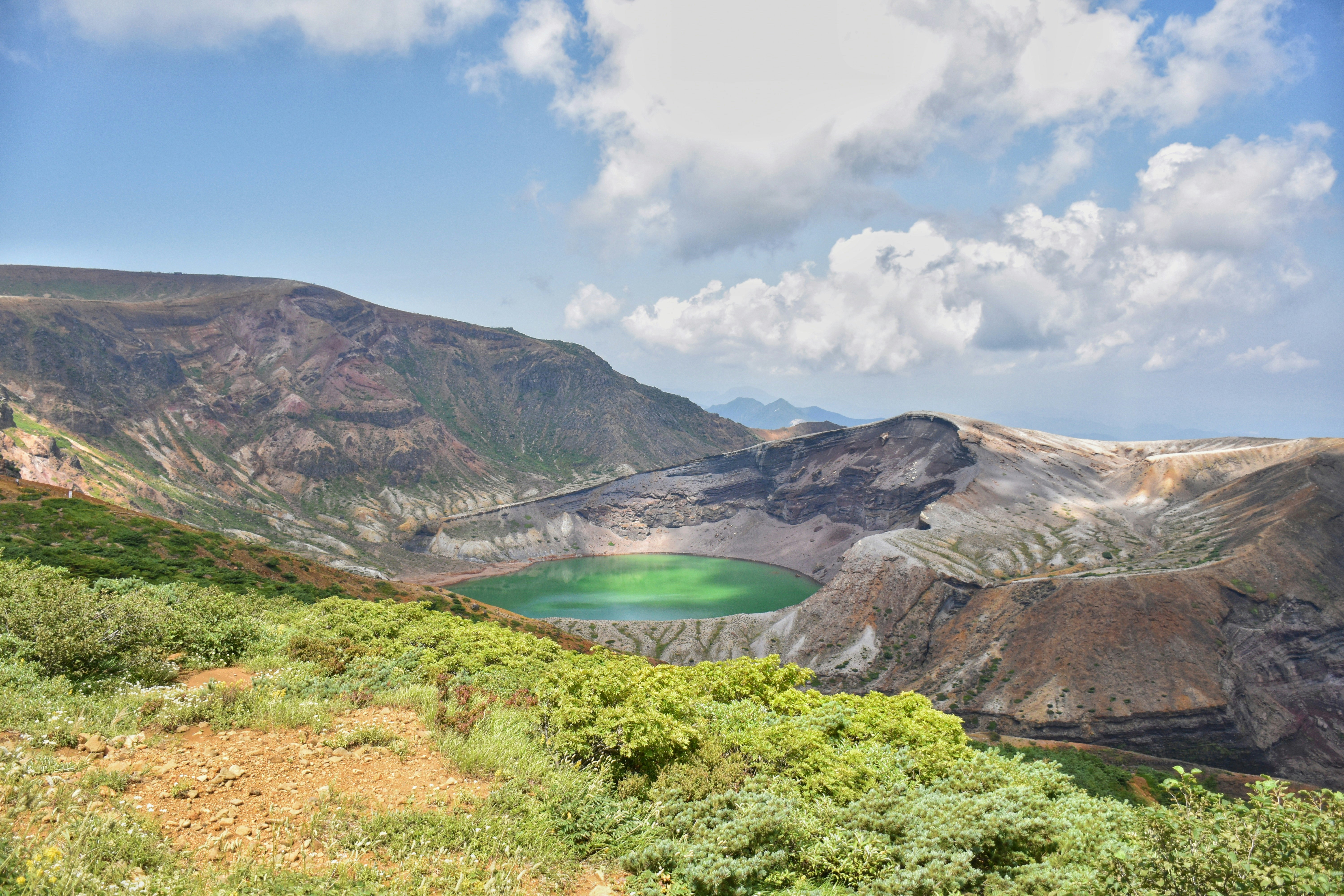 Emerald Crater Lake Quietly Gleams Above Rugged Caldera Walls