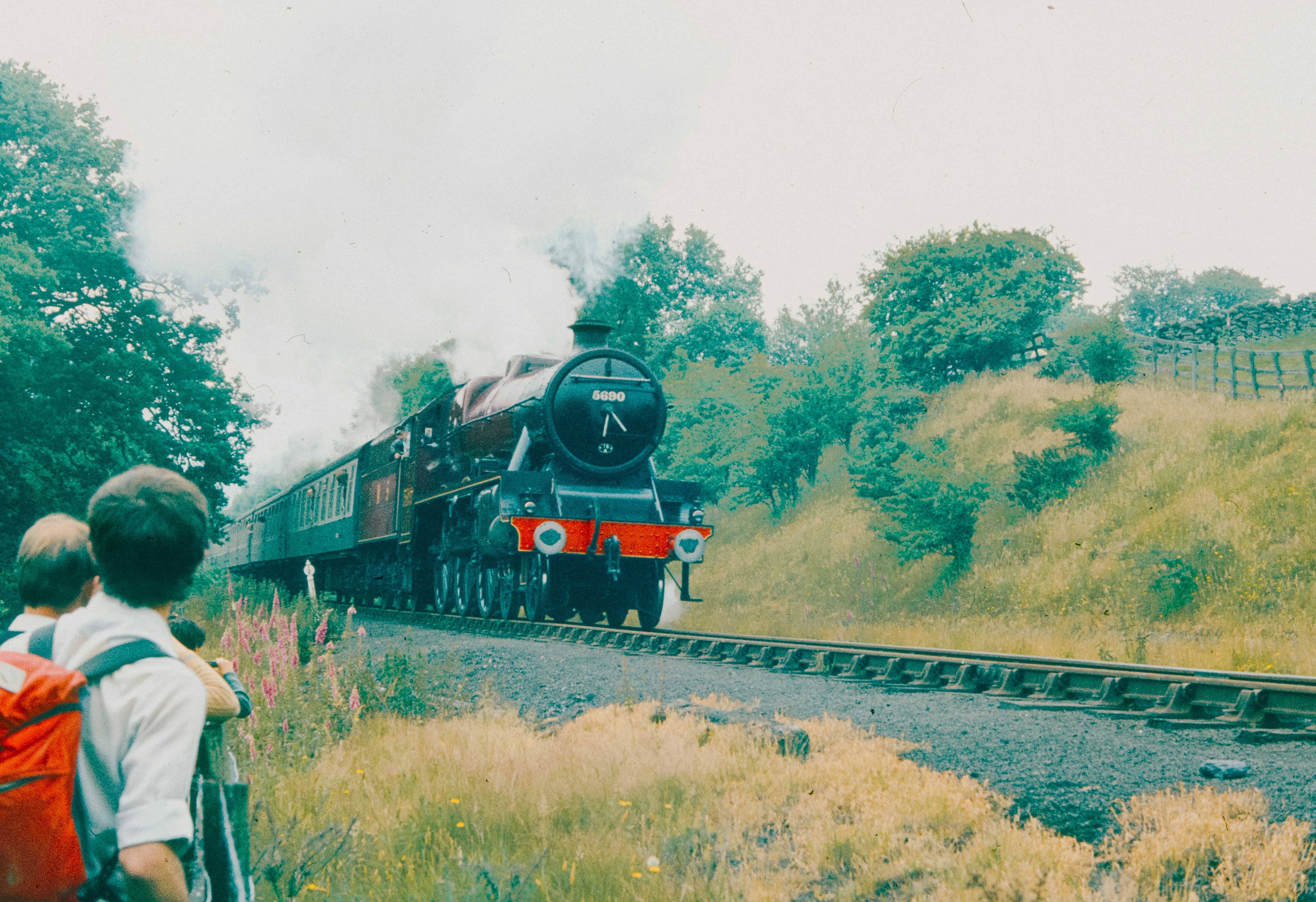 People watch a steam train going down the tracks. photo – Free Man ...