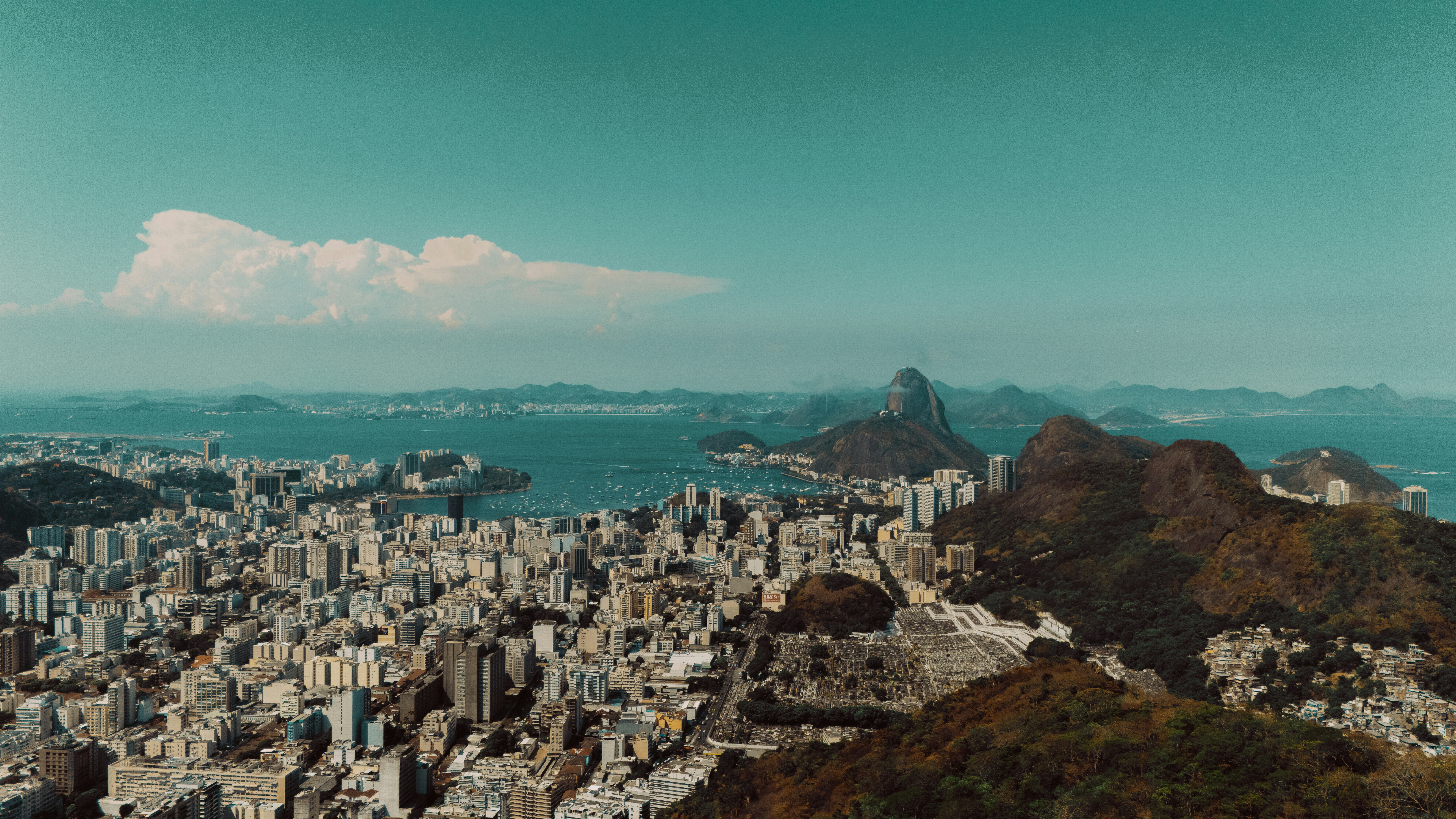 Expansive view of Rio de Janeiro's cityscape merging with lush hills and distant ocean.