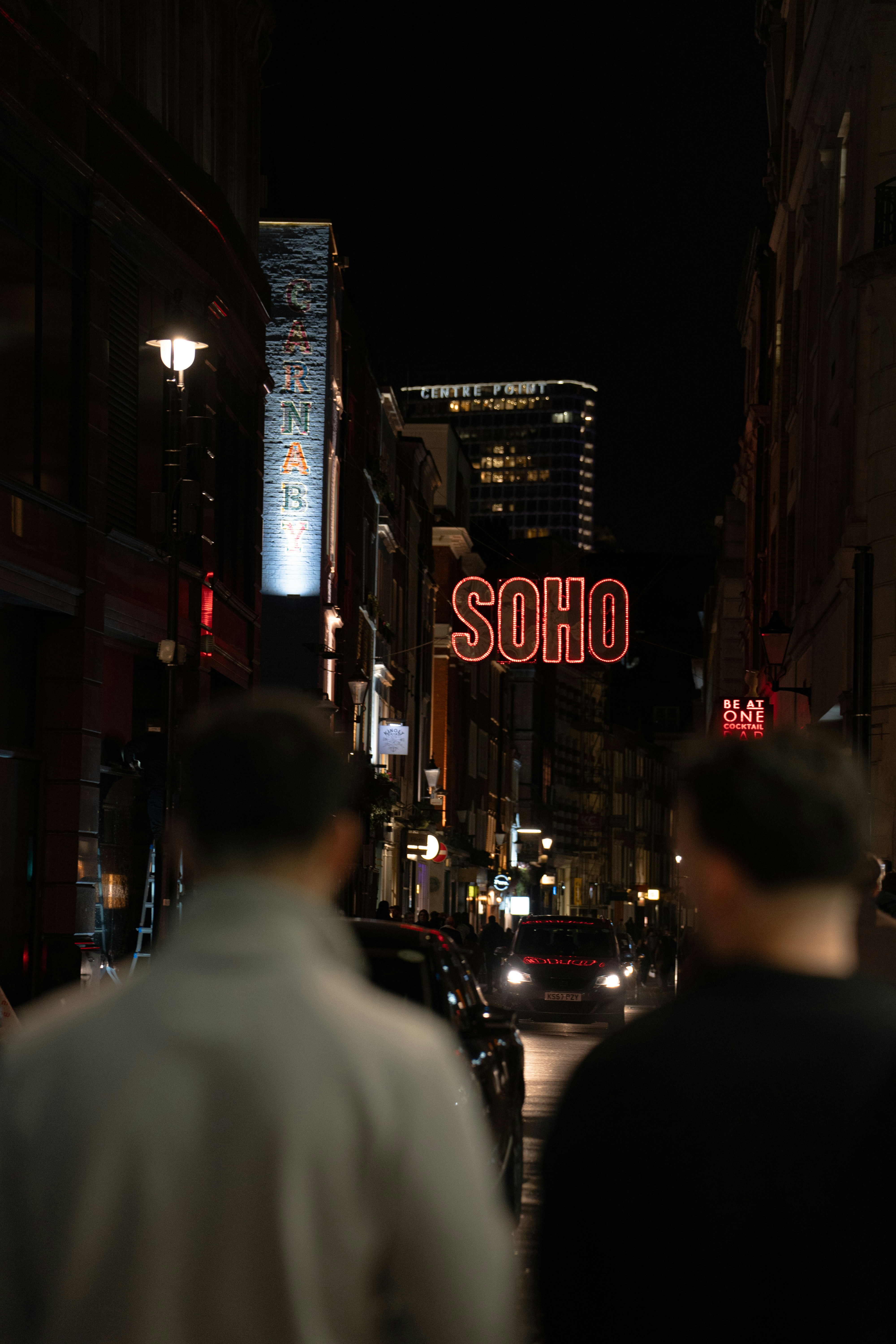 La gente camina hacia el letrero iluminado del Soho. foto – Imagen de Coche gratuita en Unsplash