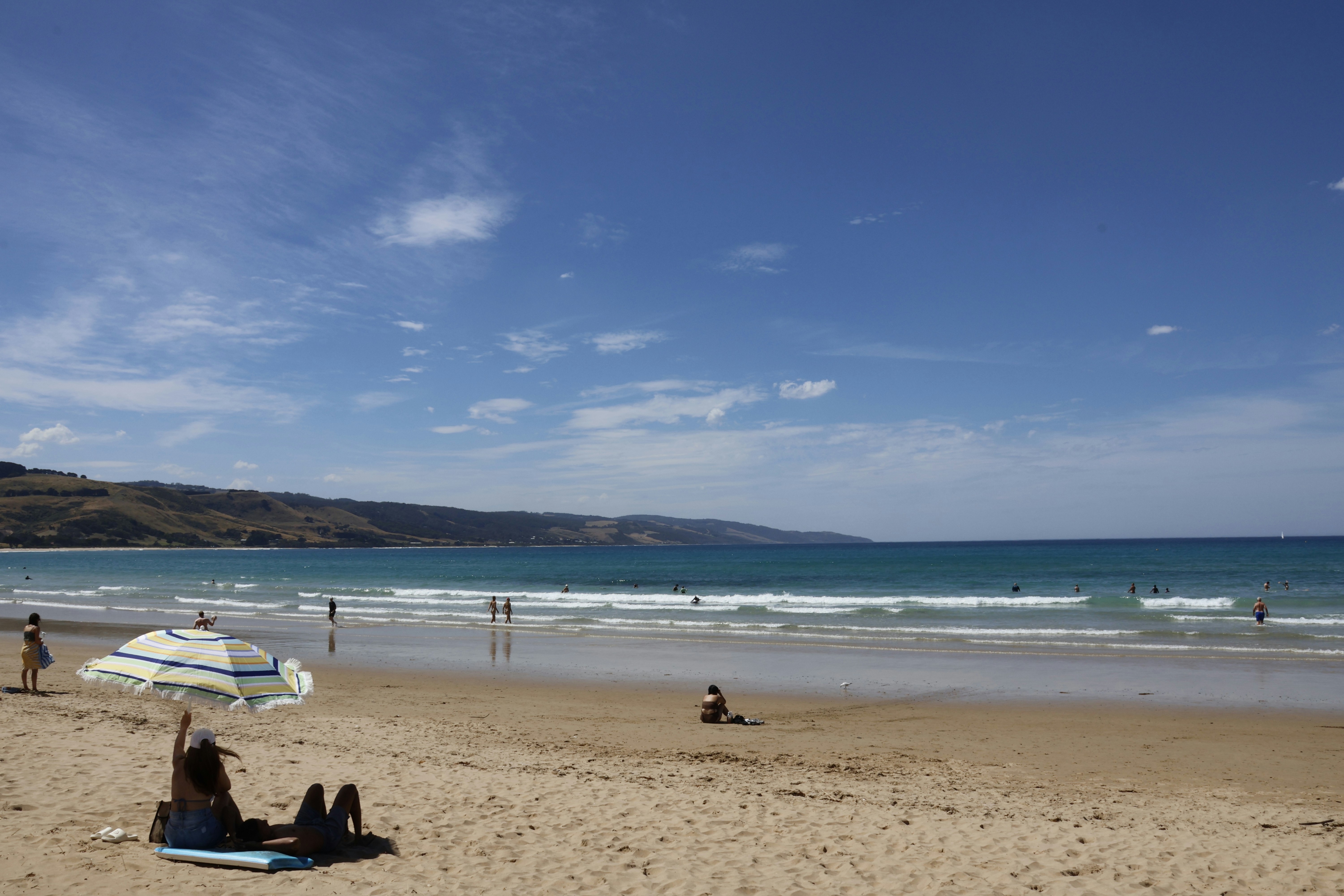 Beachgoers enjoy a sunny day by the ocean. photo – Free Beach Image on ...