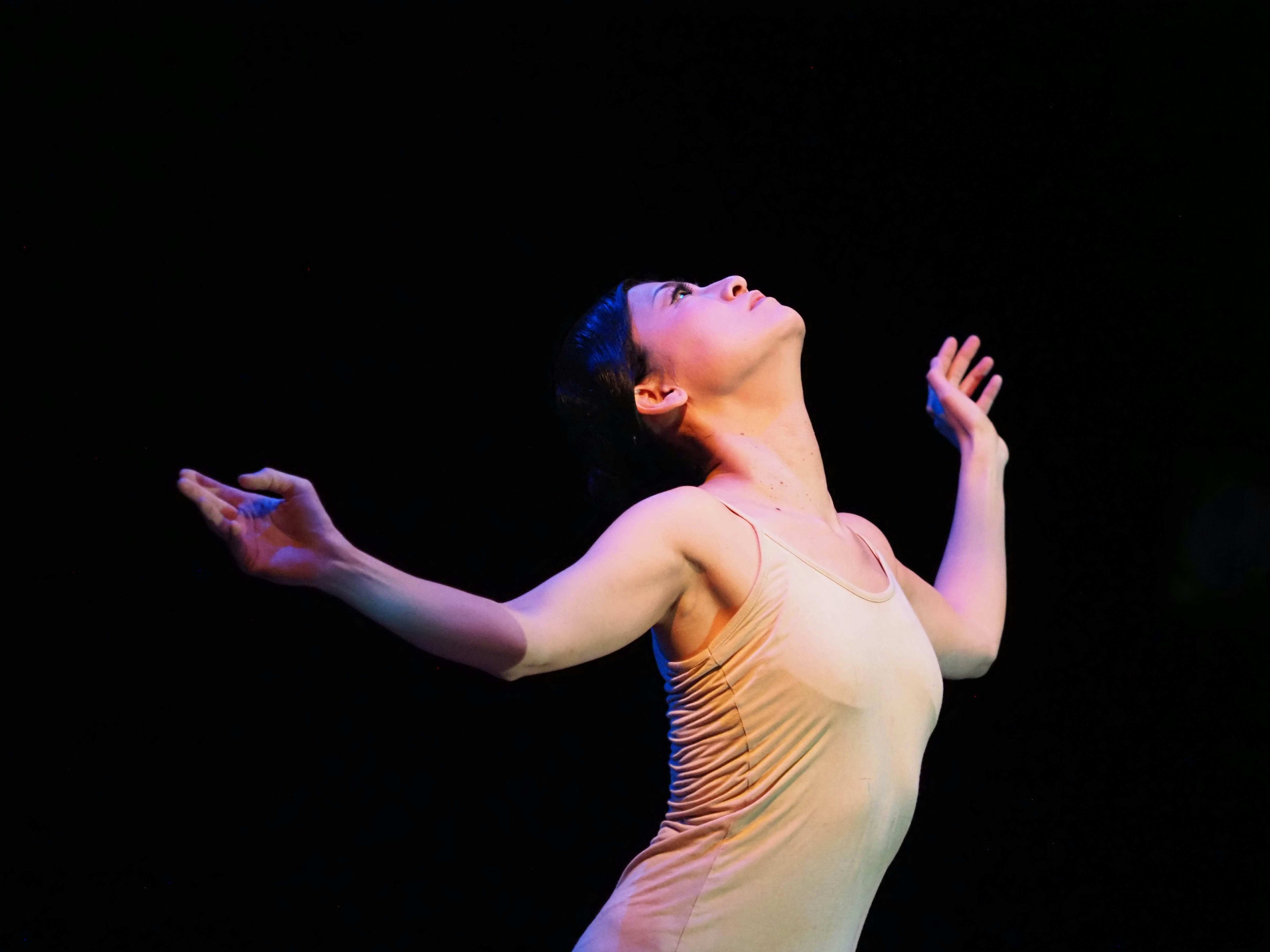 A dancer poses with arms outstretched in a performance. photo – Free ...