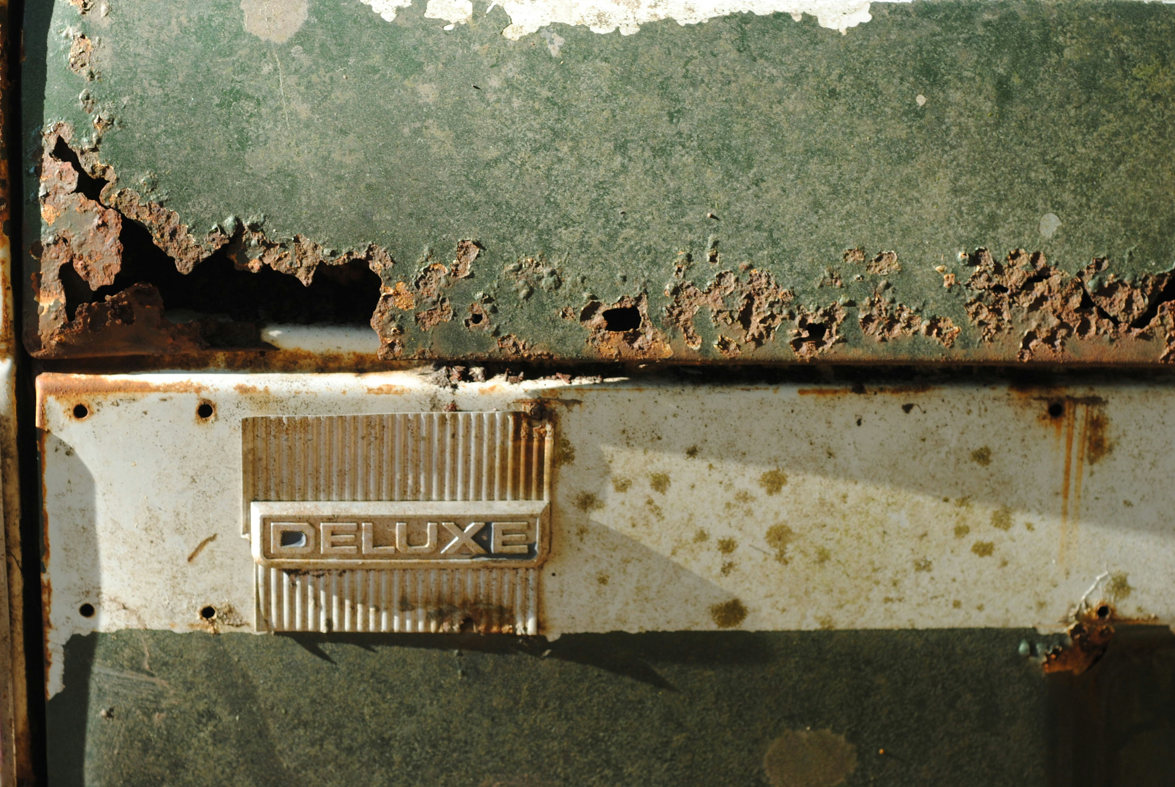 Rusty car door with "deluxe" emblem. photo – Free Rust Image on Unsplash