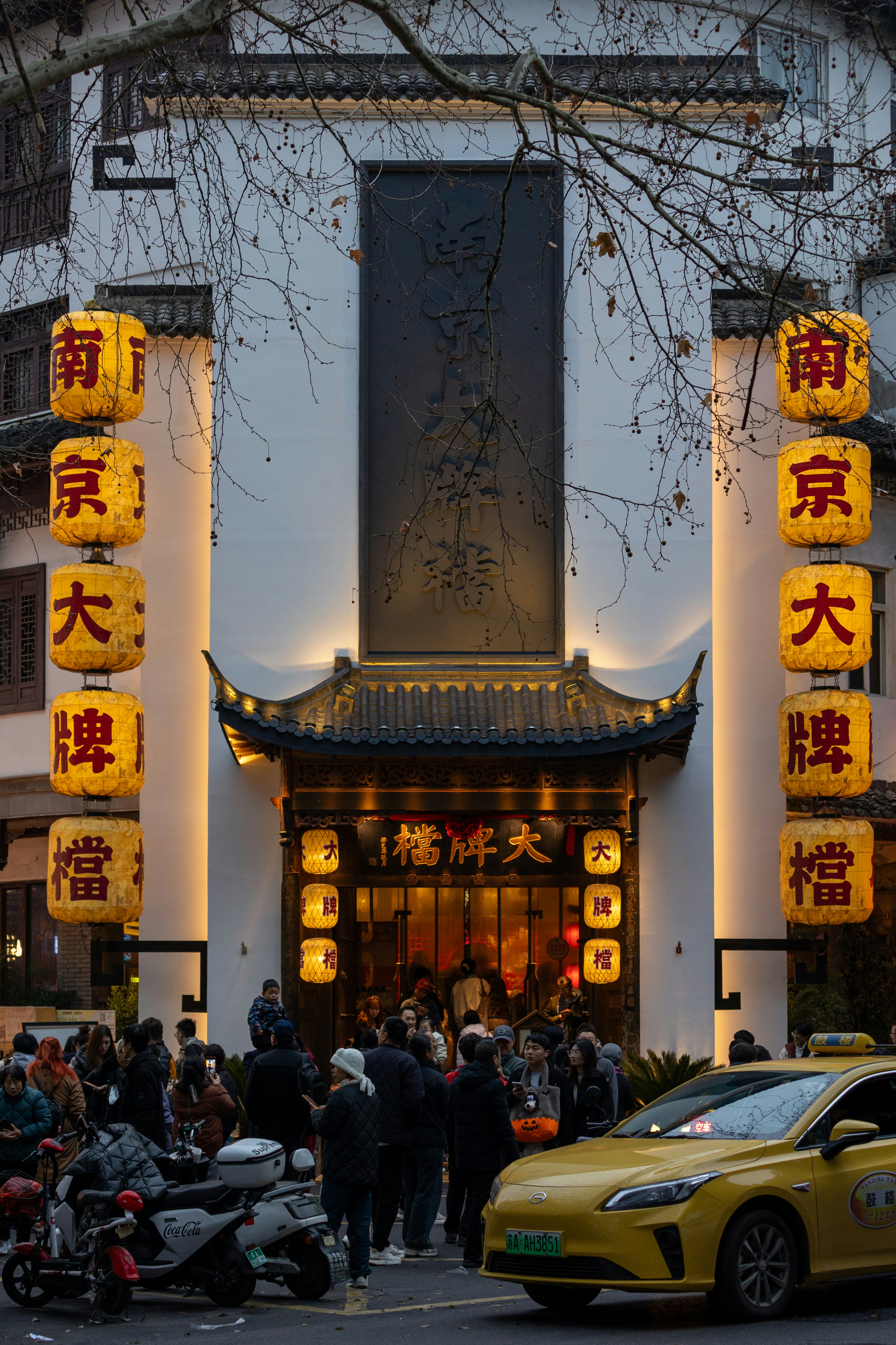 Lantern-Lit Portal: Crowds Gather at a Traditional Shop Front at Dusk