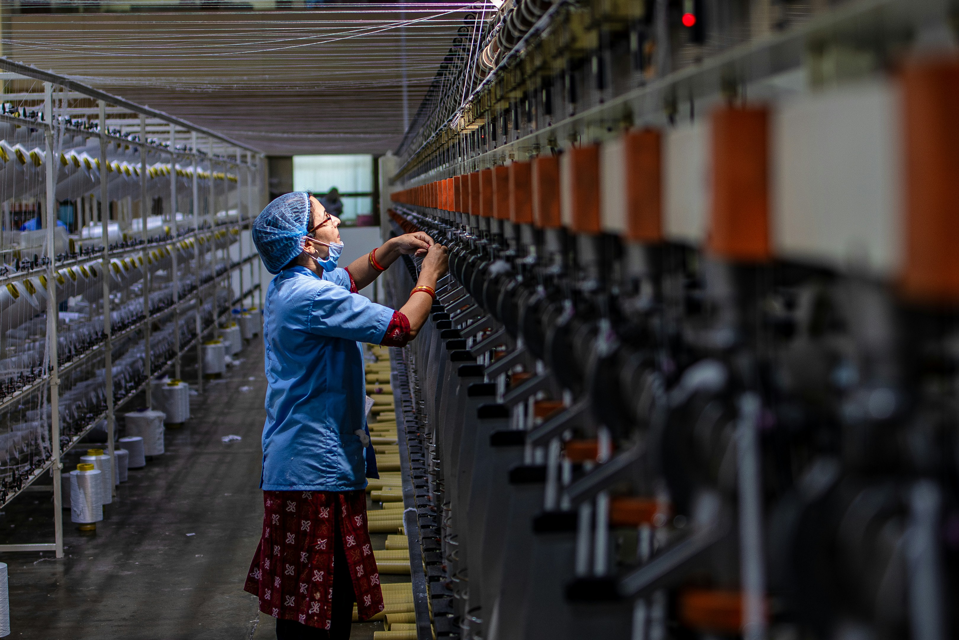 Woman working in a textile factory, operating machines. photo – Free ...