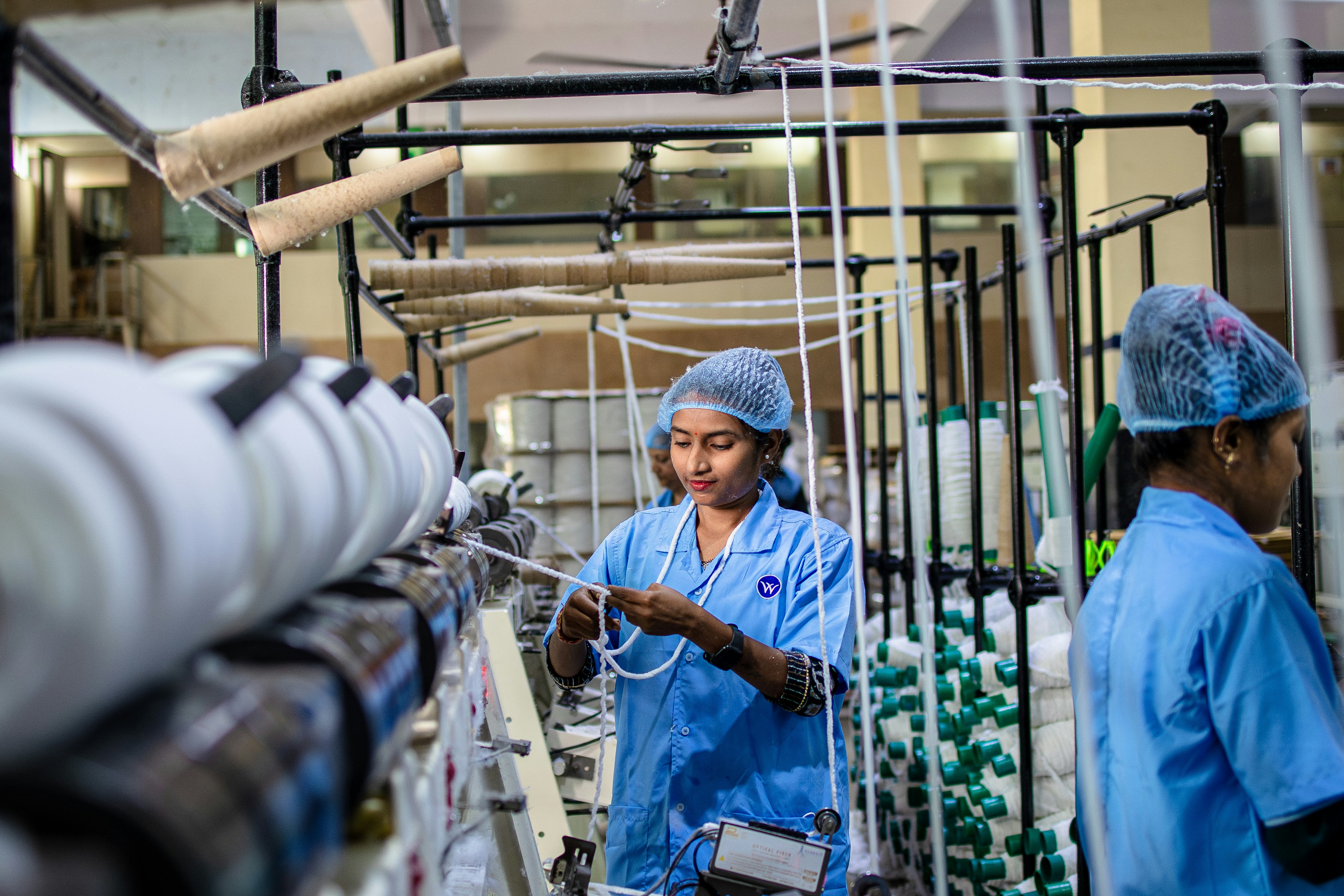 Factory workers operate textile machinery in a factory. photo – Free ...