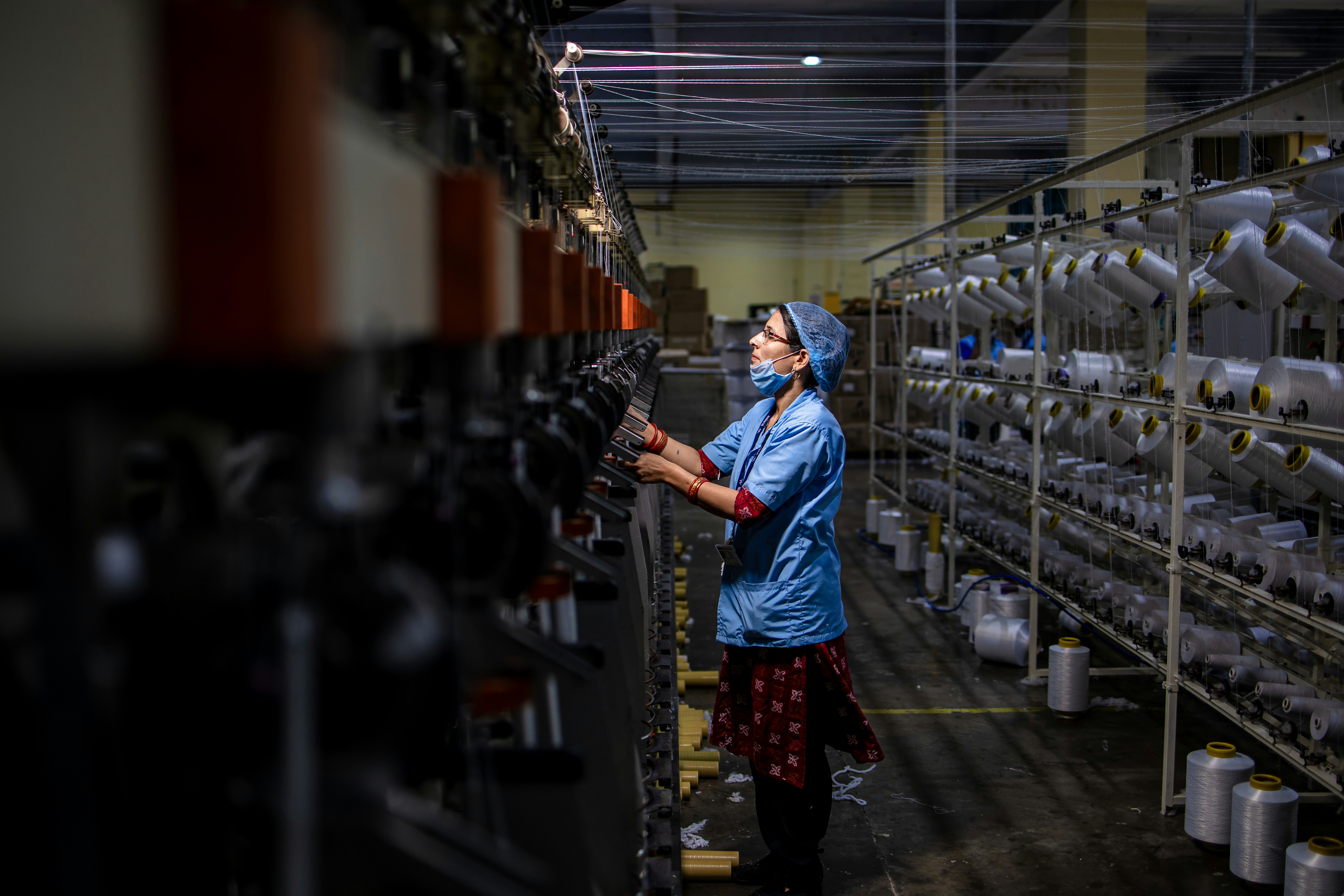 Factory worker tending to machinery and threads. photo – Free Man Image ...