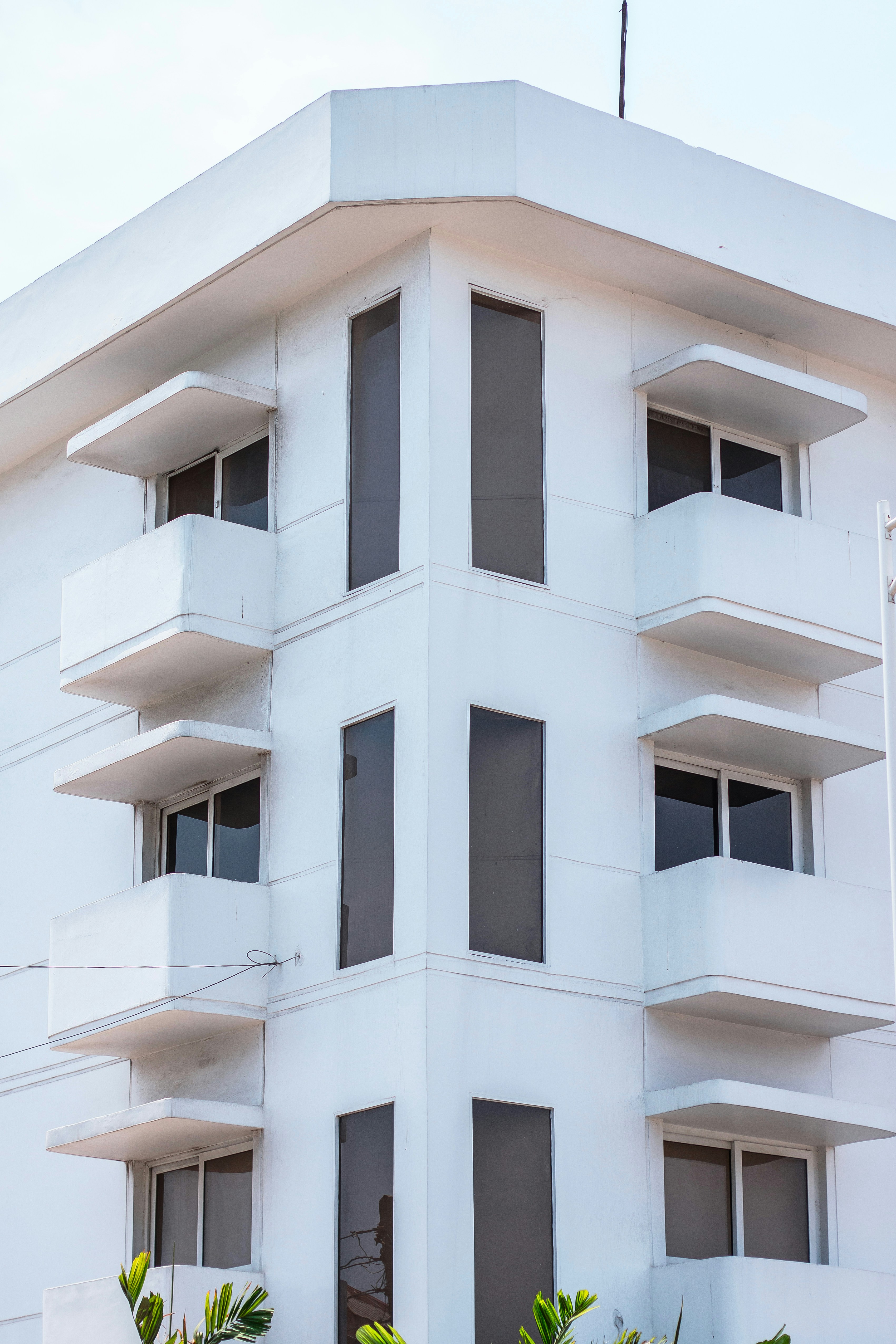 Edificio blanco en esquina con ventanas rectangulares. foto – Imagen de ...