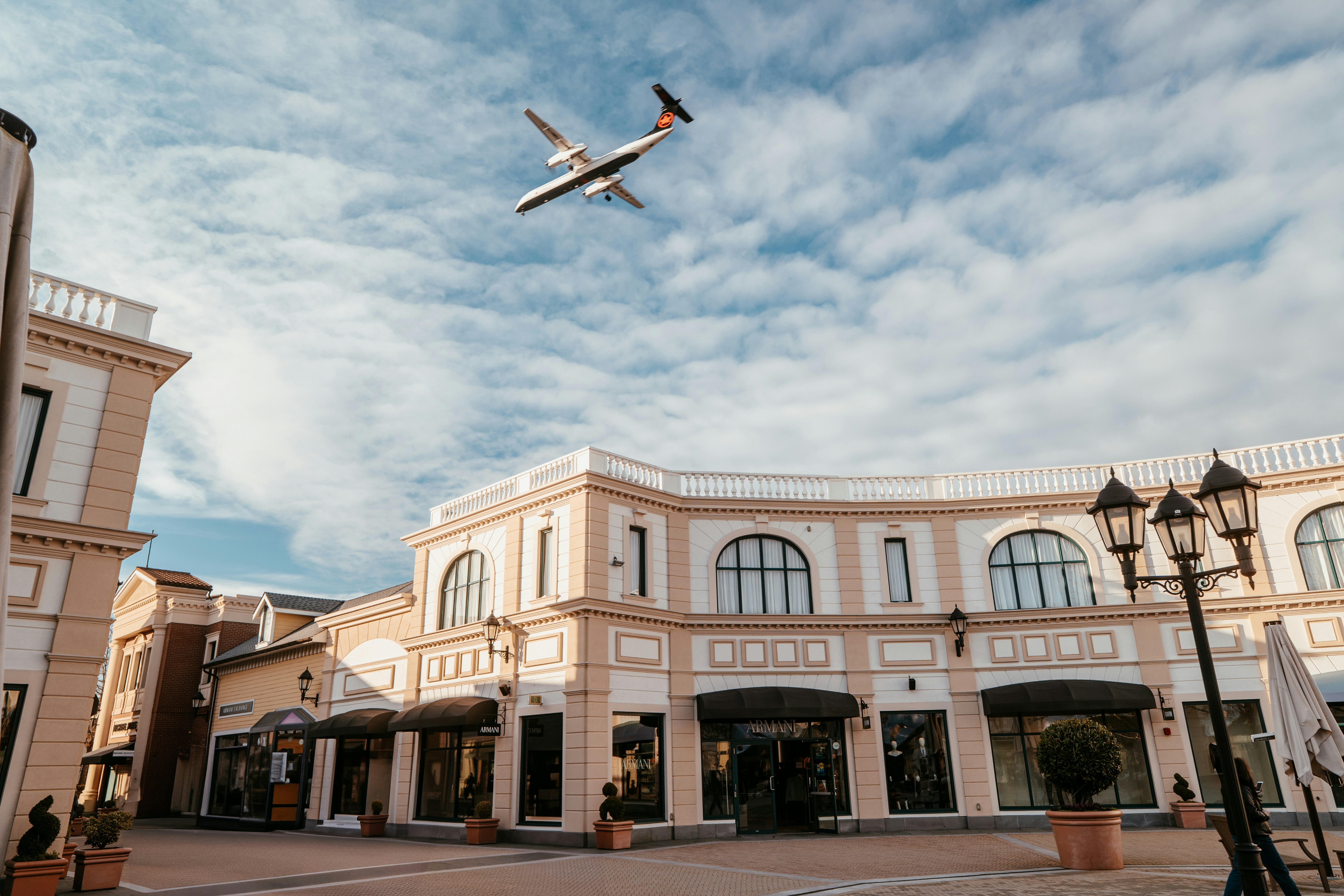 An airplane flies over a shopping center. photo – Free Building Image ...