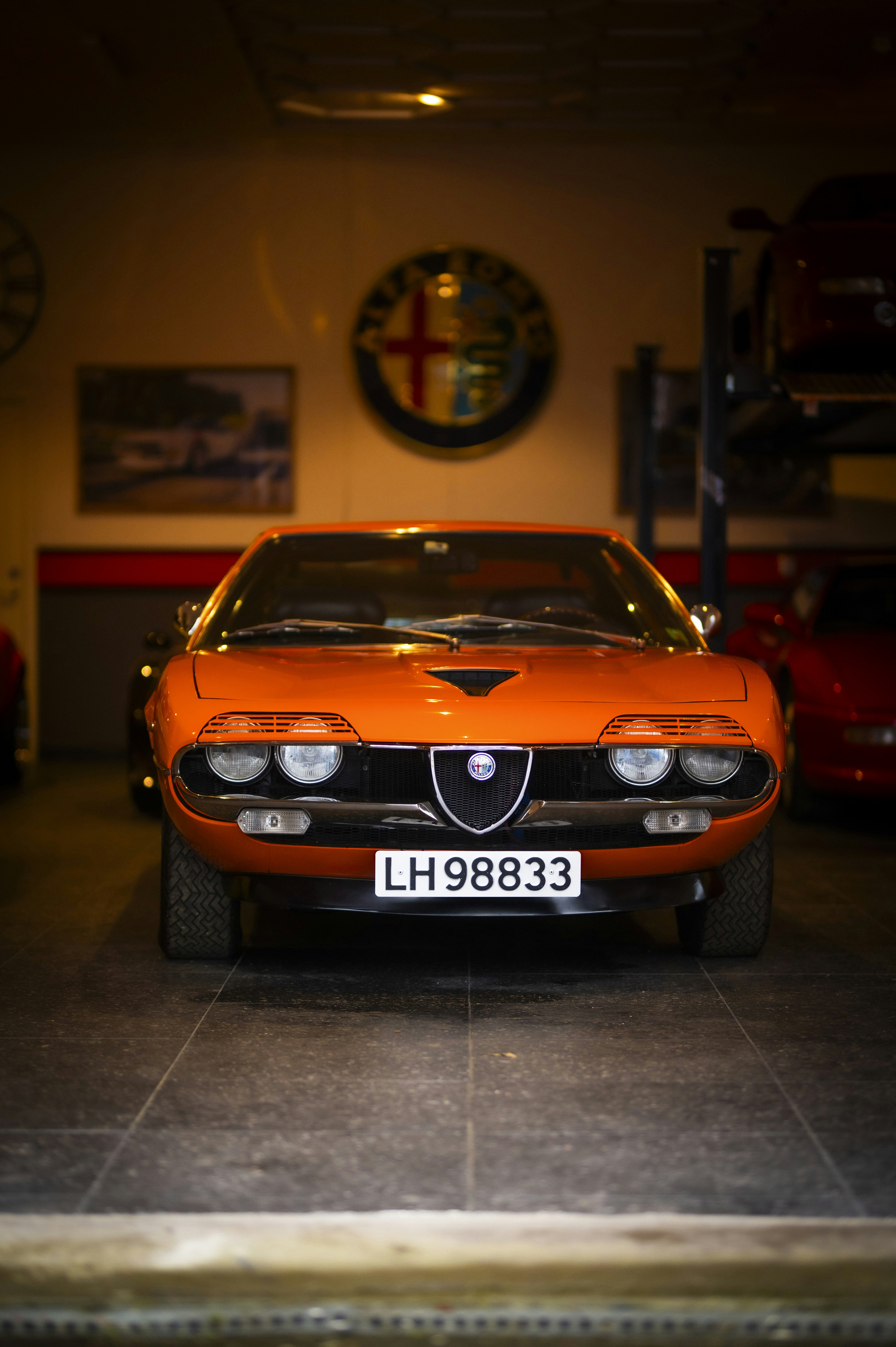 Un clásico Alfa Romeo naranja en un garaje. foto – Imagen de Coche ...