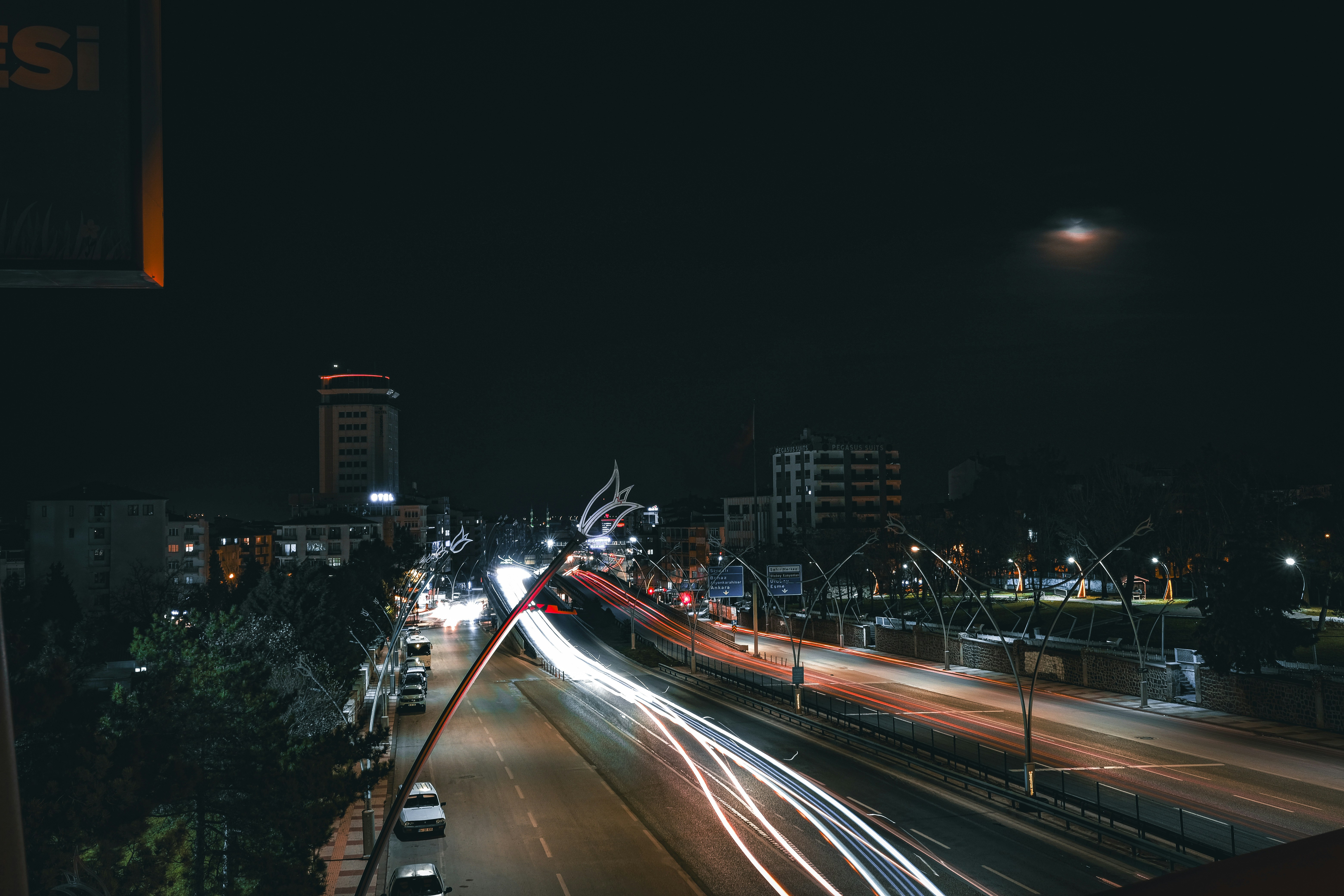 City street illuminated by vibrant light trails under a dark night sky.