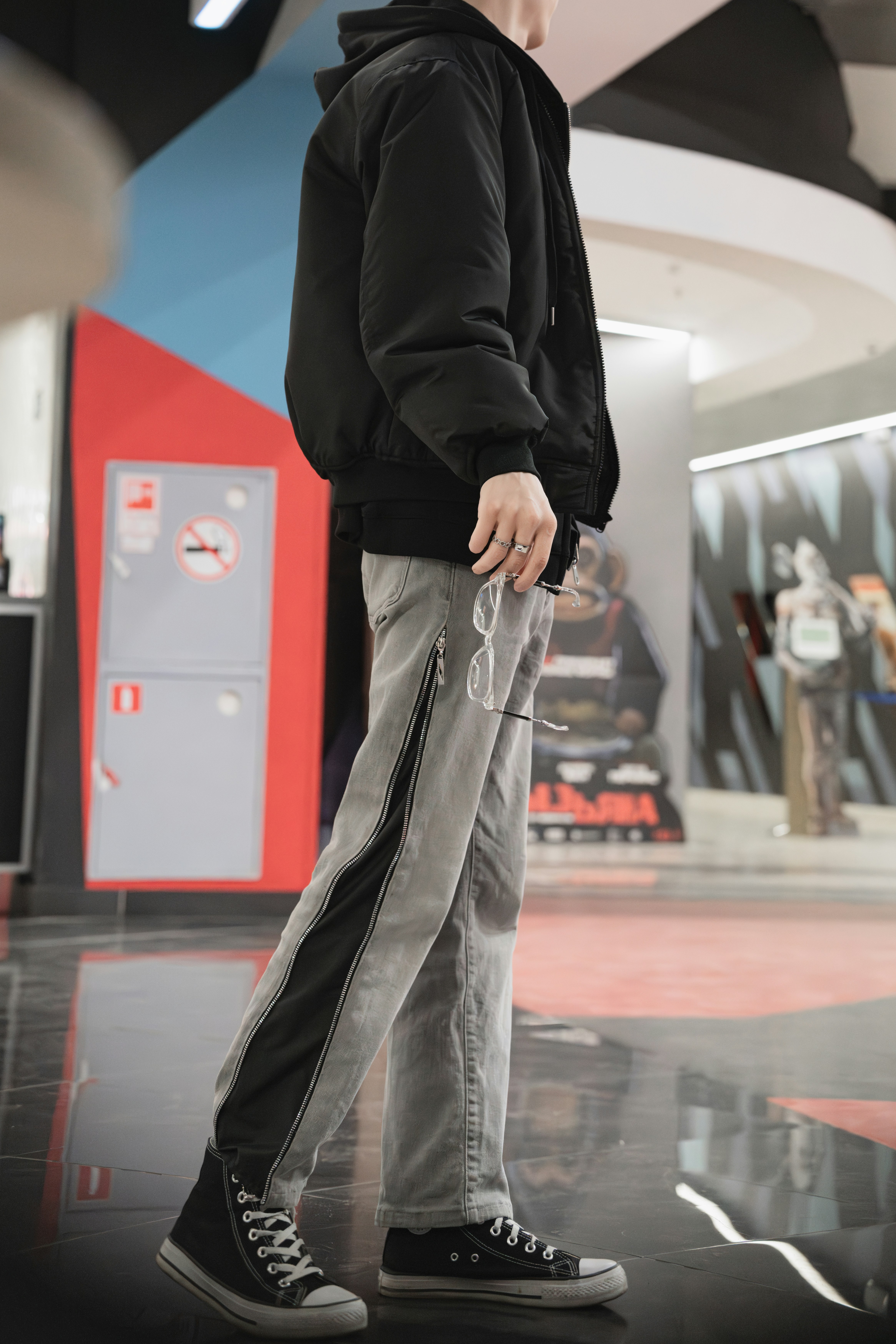 Neon Corridor Moment: Casual Stance with Glasses in Hand