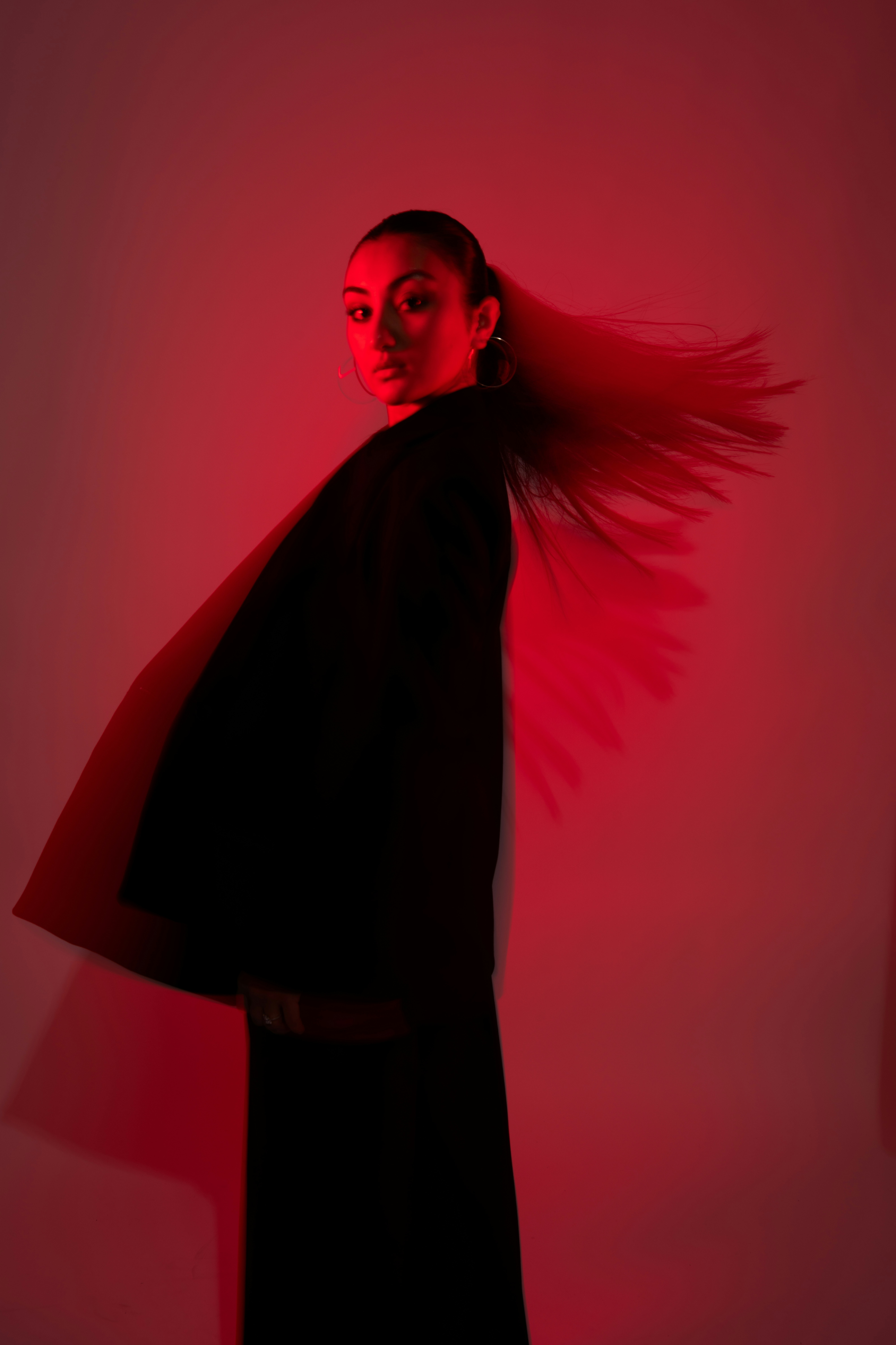 Woman in black, lit dramatically with red light. photo – Free Fashion ...