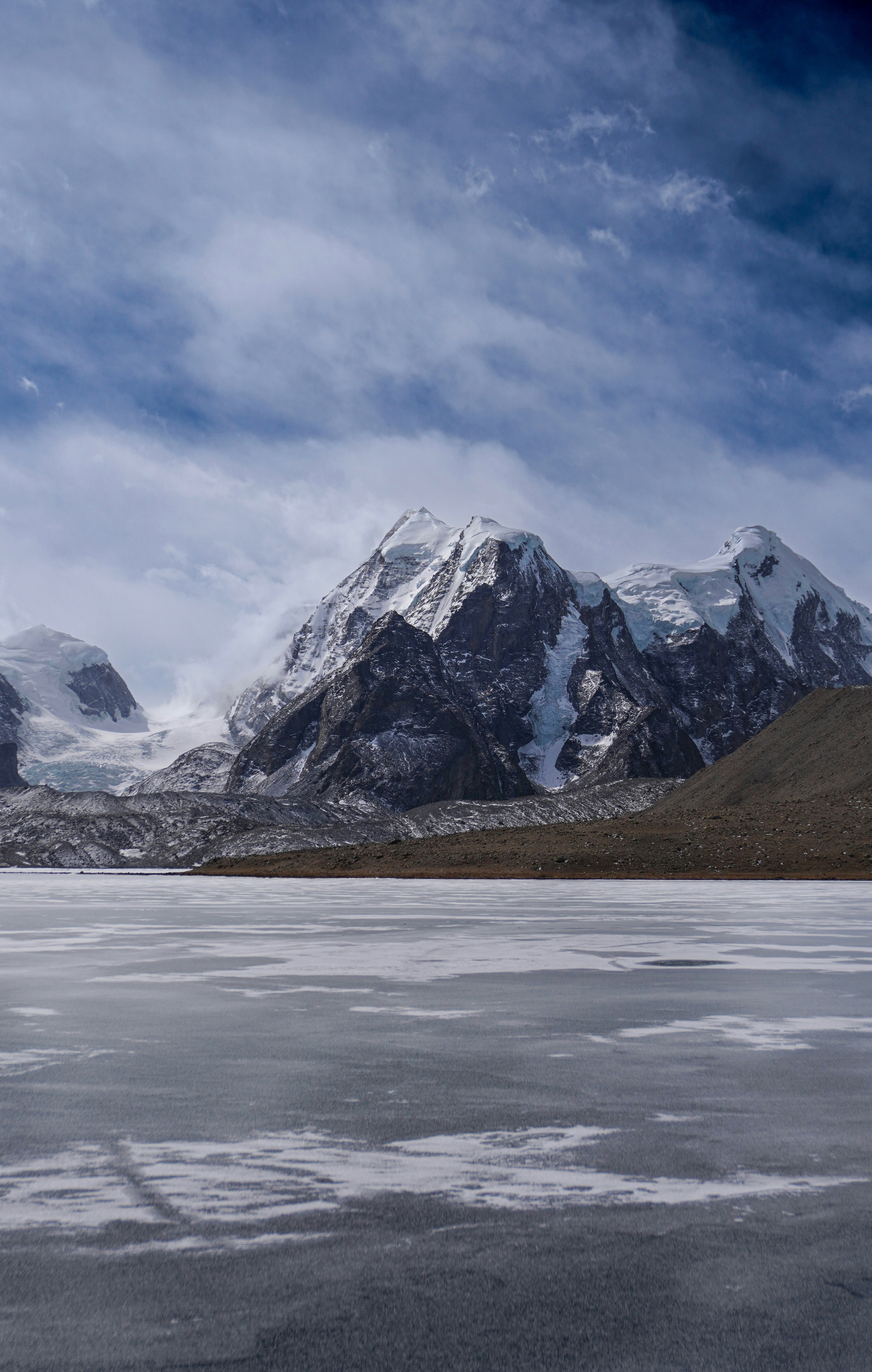 Montañas nevadas se elevan sobre un lago congelado. foto – Imagen de ...