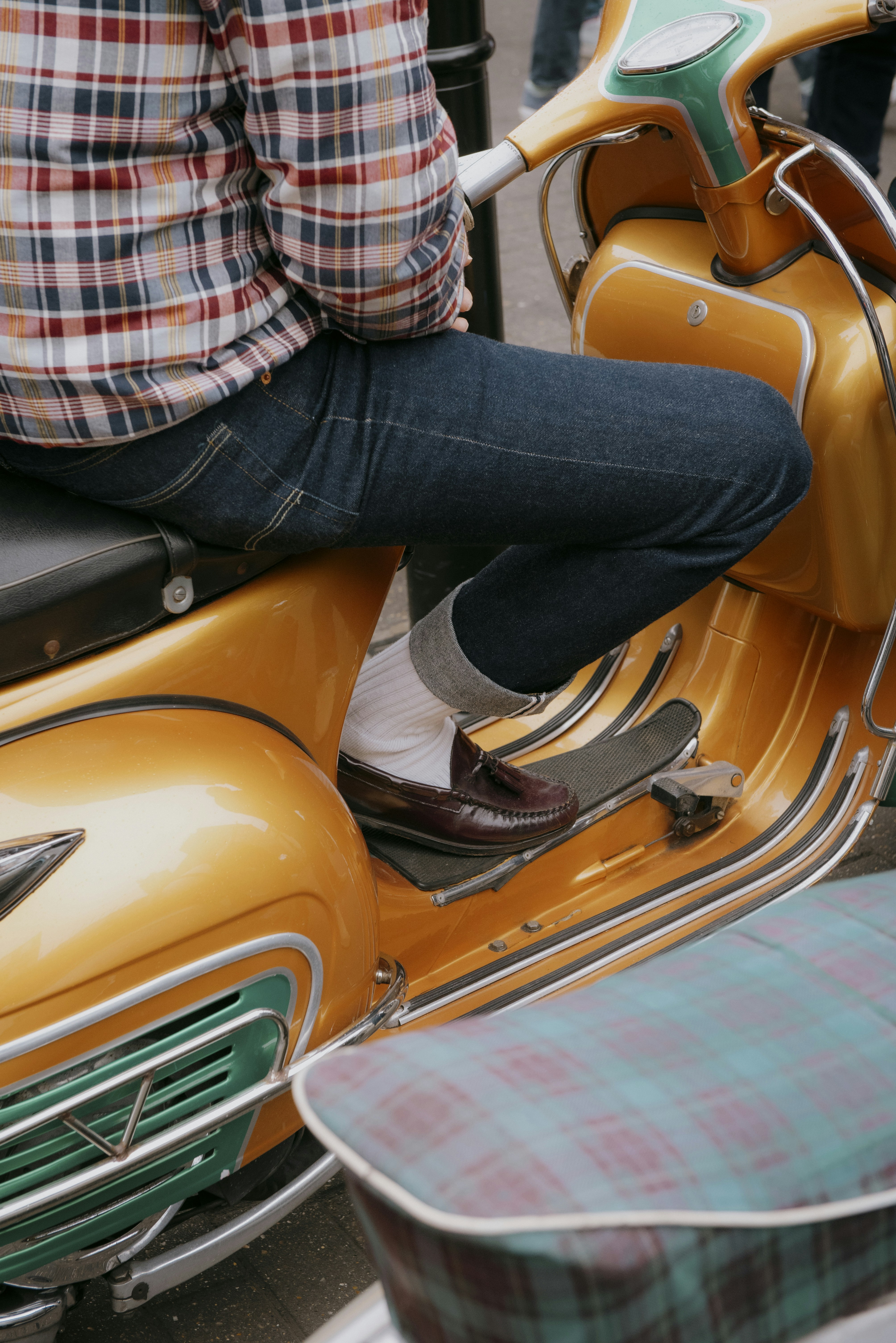 Die Person sitzt auf einem Oldtimer-Roller und ist bereit zu fahren ...