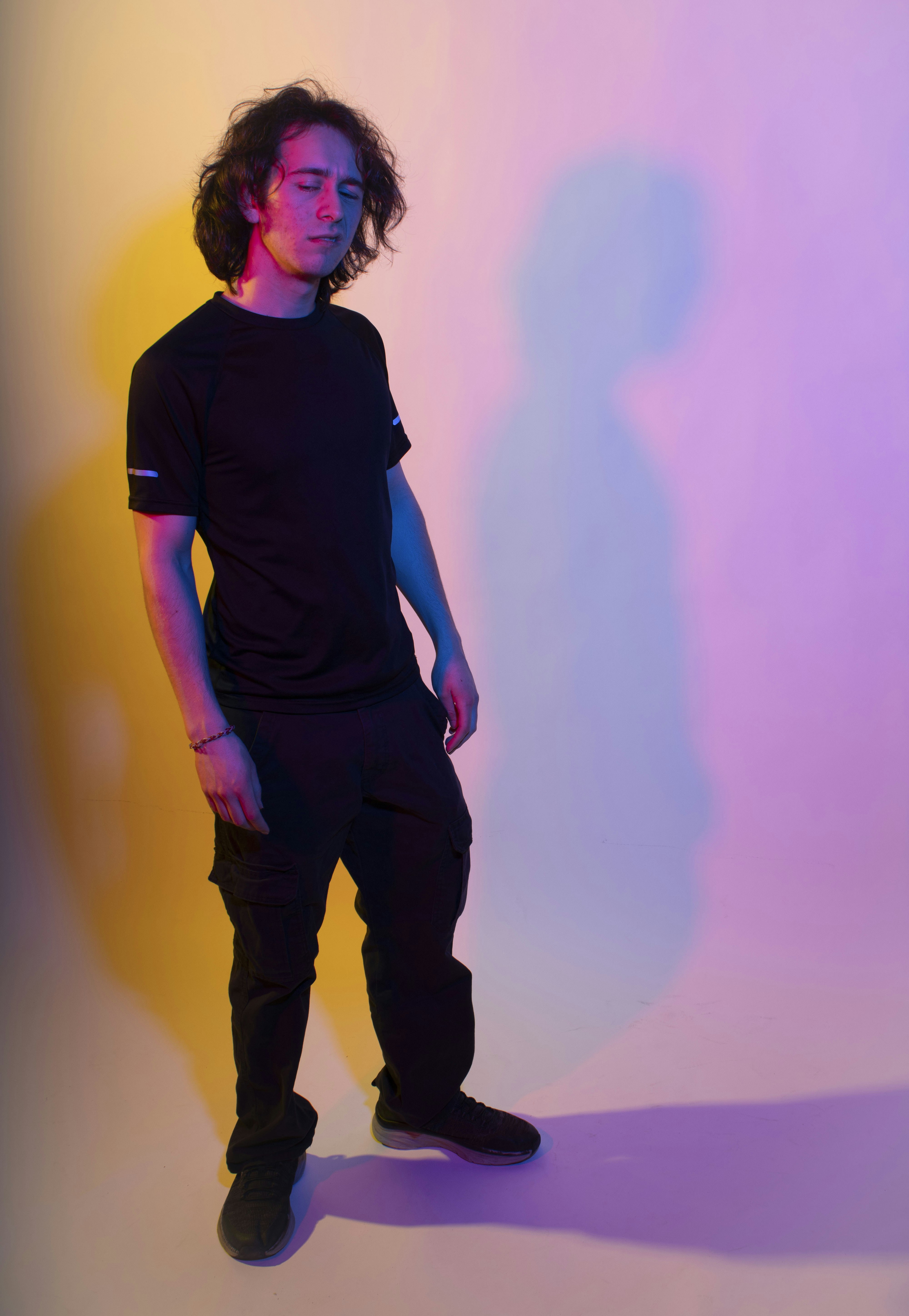 Man posing against a multicolored background with shadow. photo – Free ...