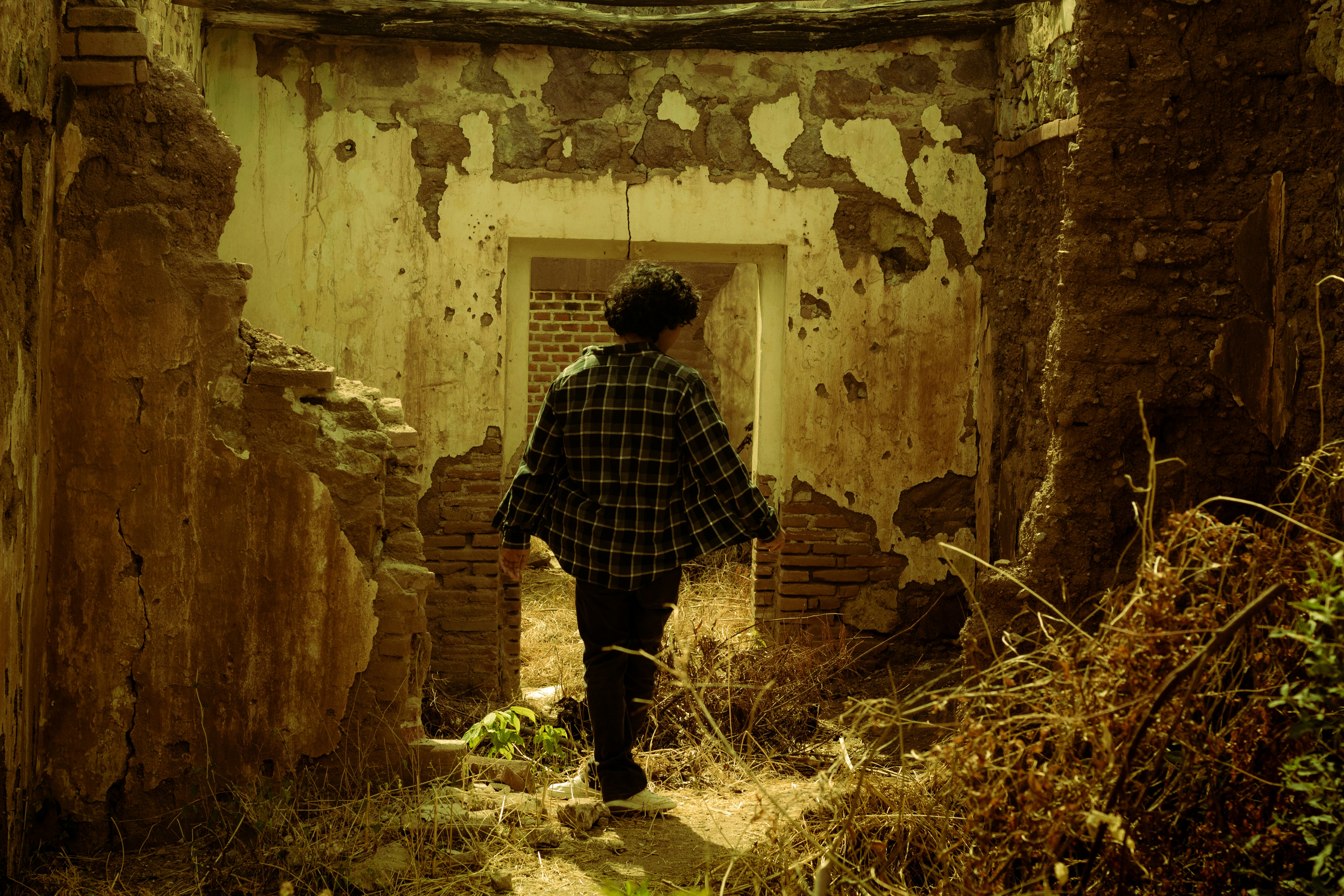 Person walks toward an opening in a crumbling building. photo – Free ...
