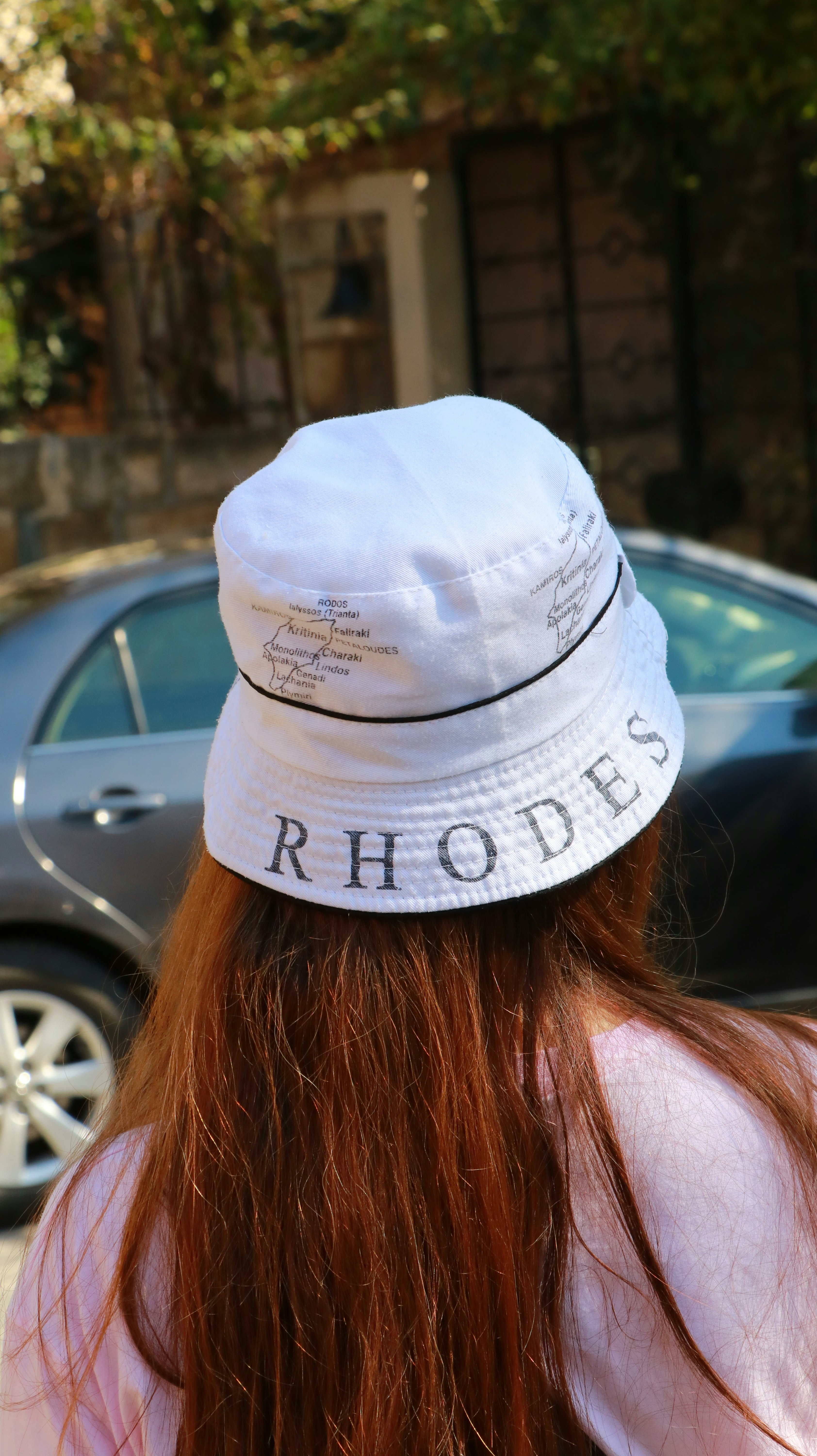 Atlas on the Back: A Quiet Street Portrait Centered on a White Bucket Hat