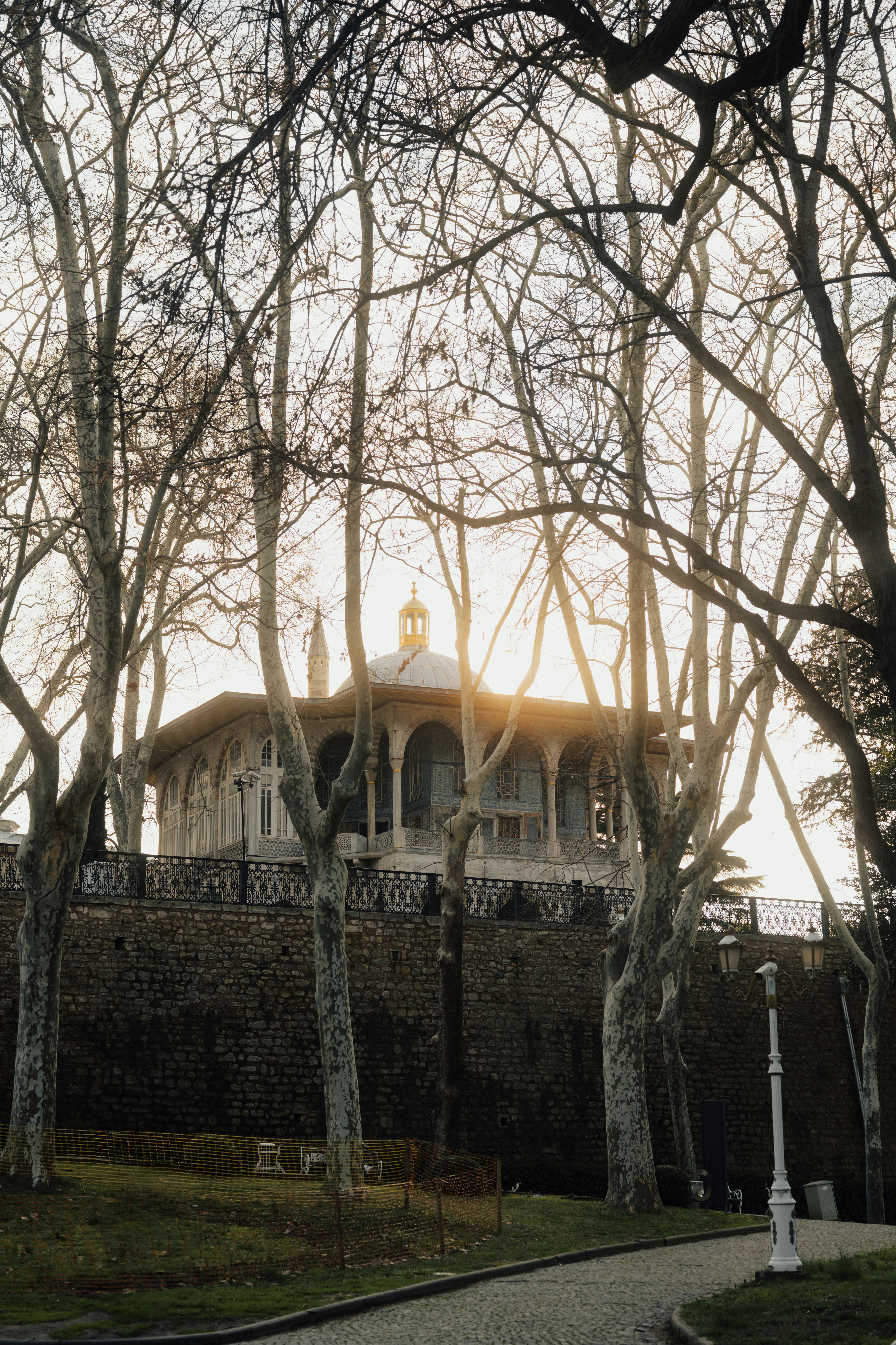 Sunlit Pavilion Above a Stone Terrace Framed by Winter Trees