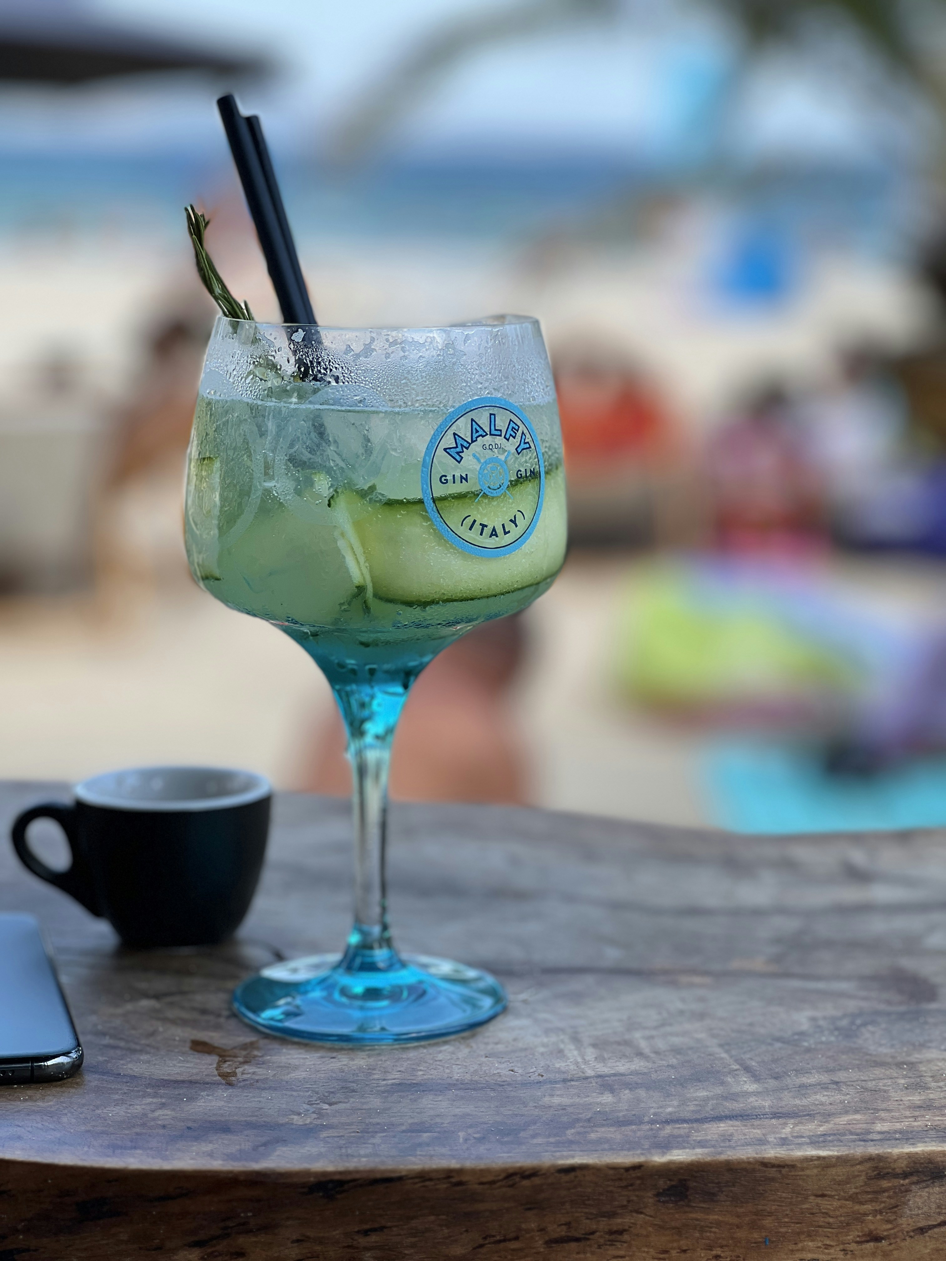 Blue cocktail at a sunlit beachside table