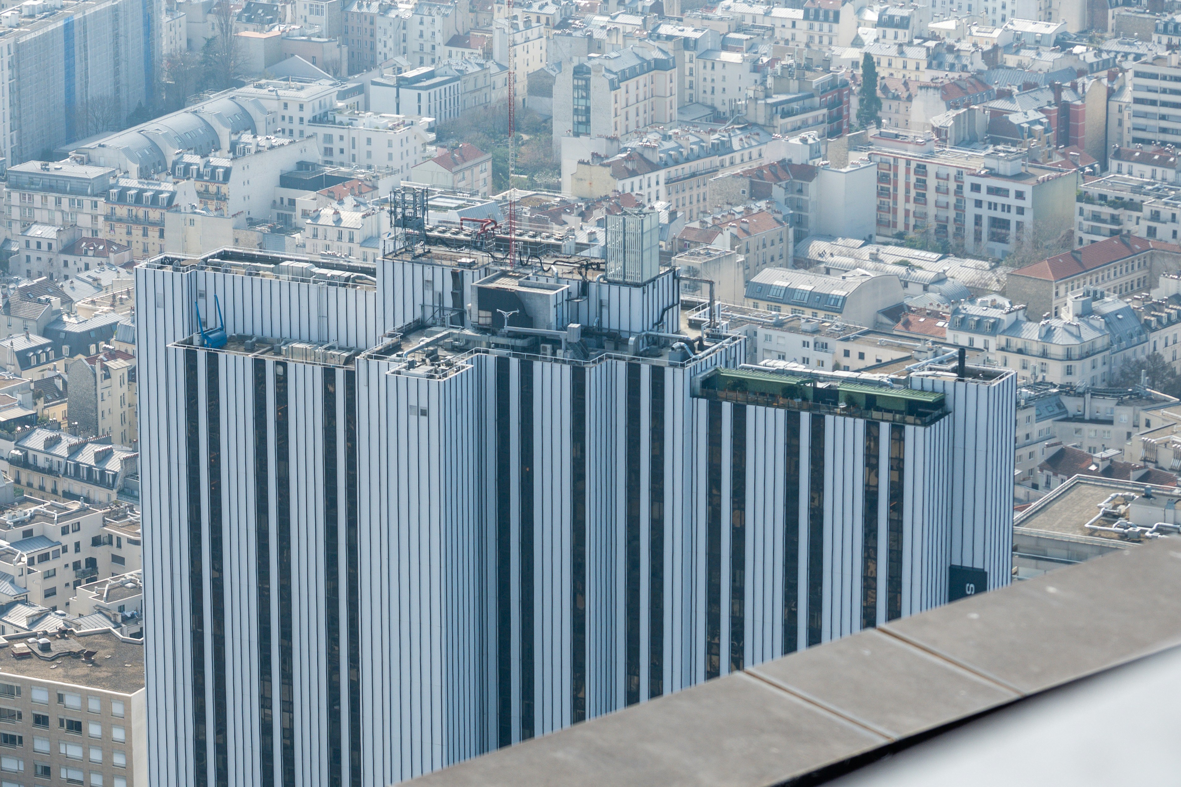 Tall building with a rooftop view overlooking a densely packed cityscape.
