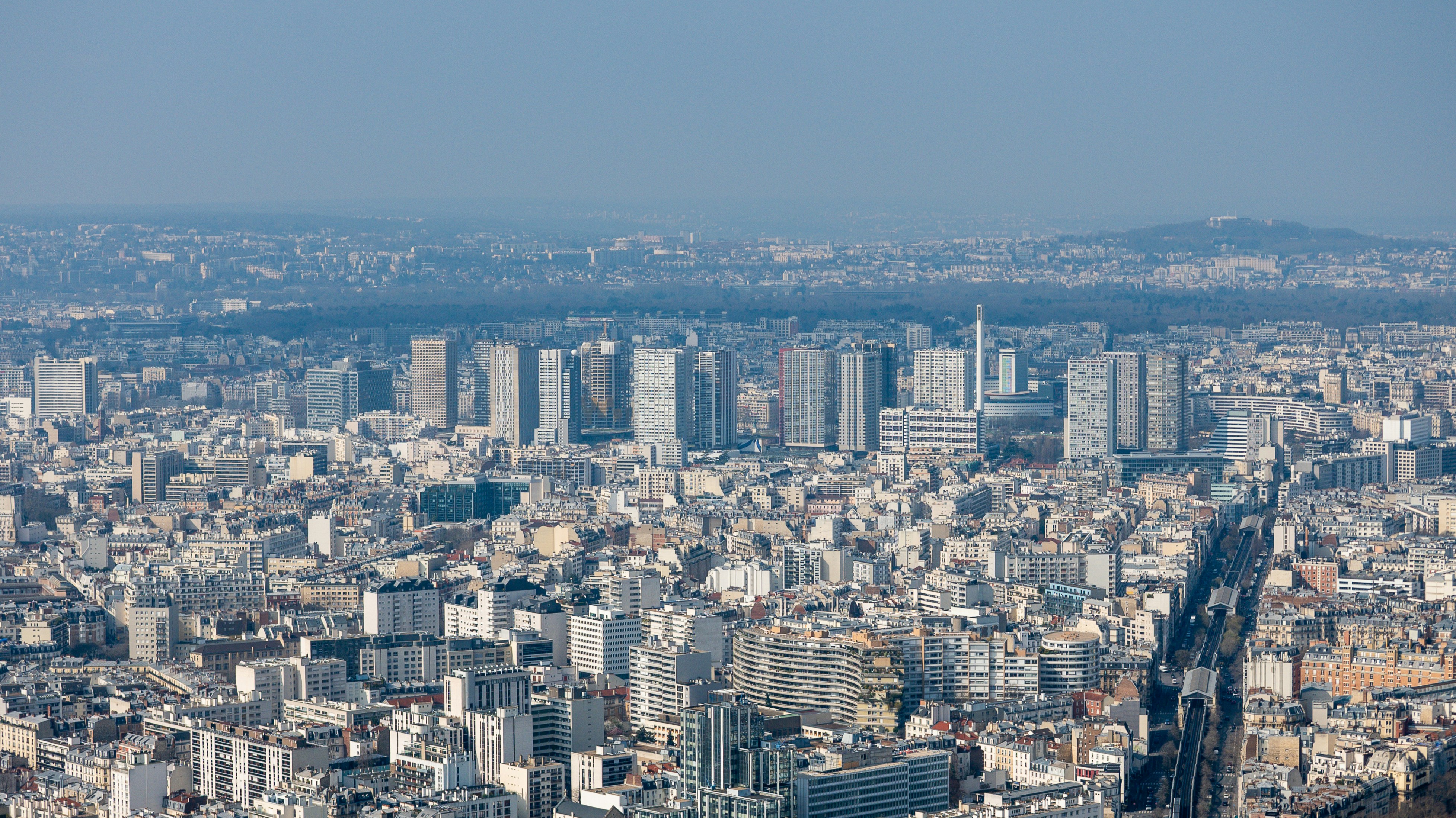 Skyline view of Paris's 15th arrondissement with modern towers and sprawling cityscape under a clear blue sky.