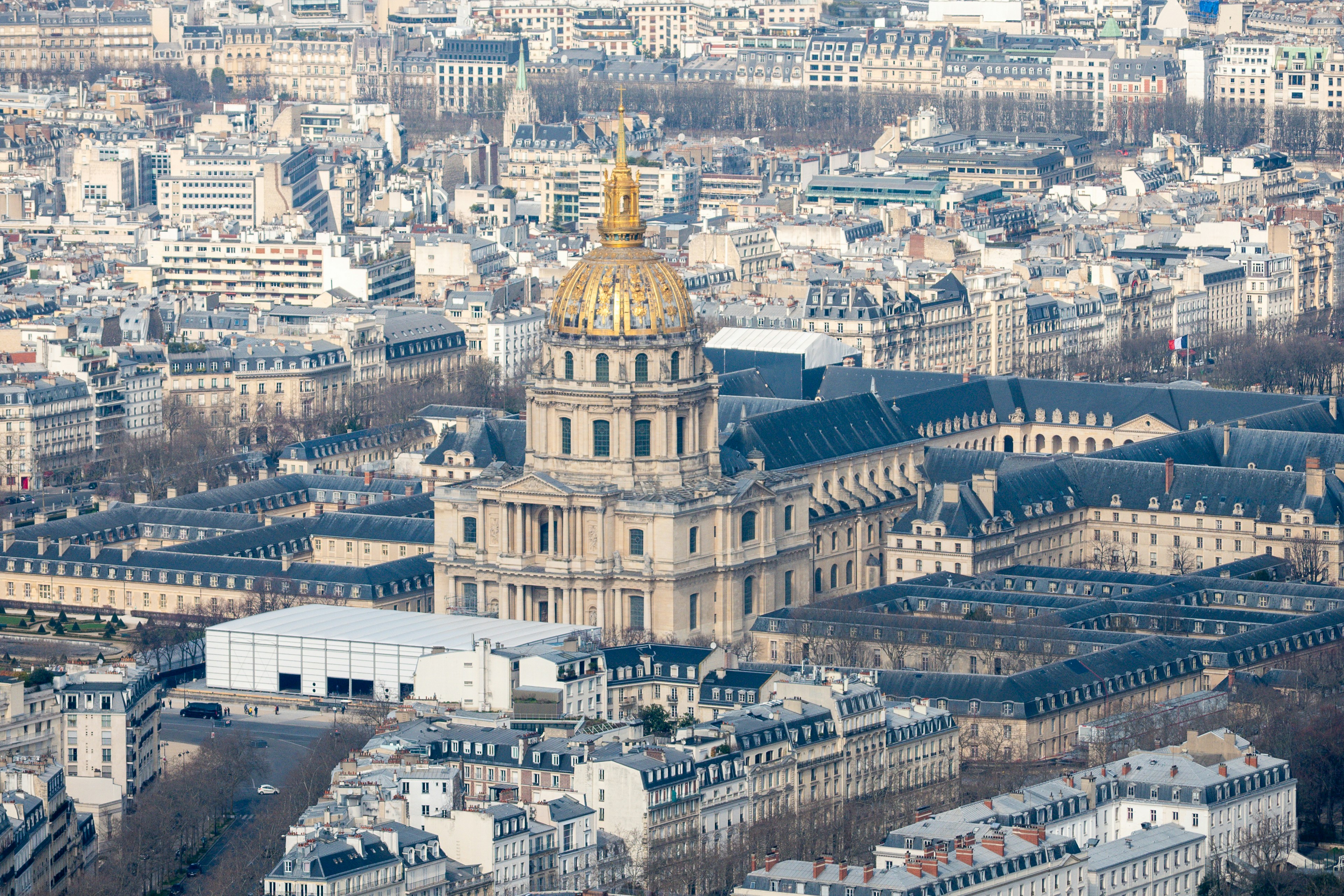 Aerial view of Les Invalides with its golden dome shining above the cityscape of Paris.