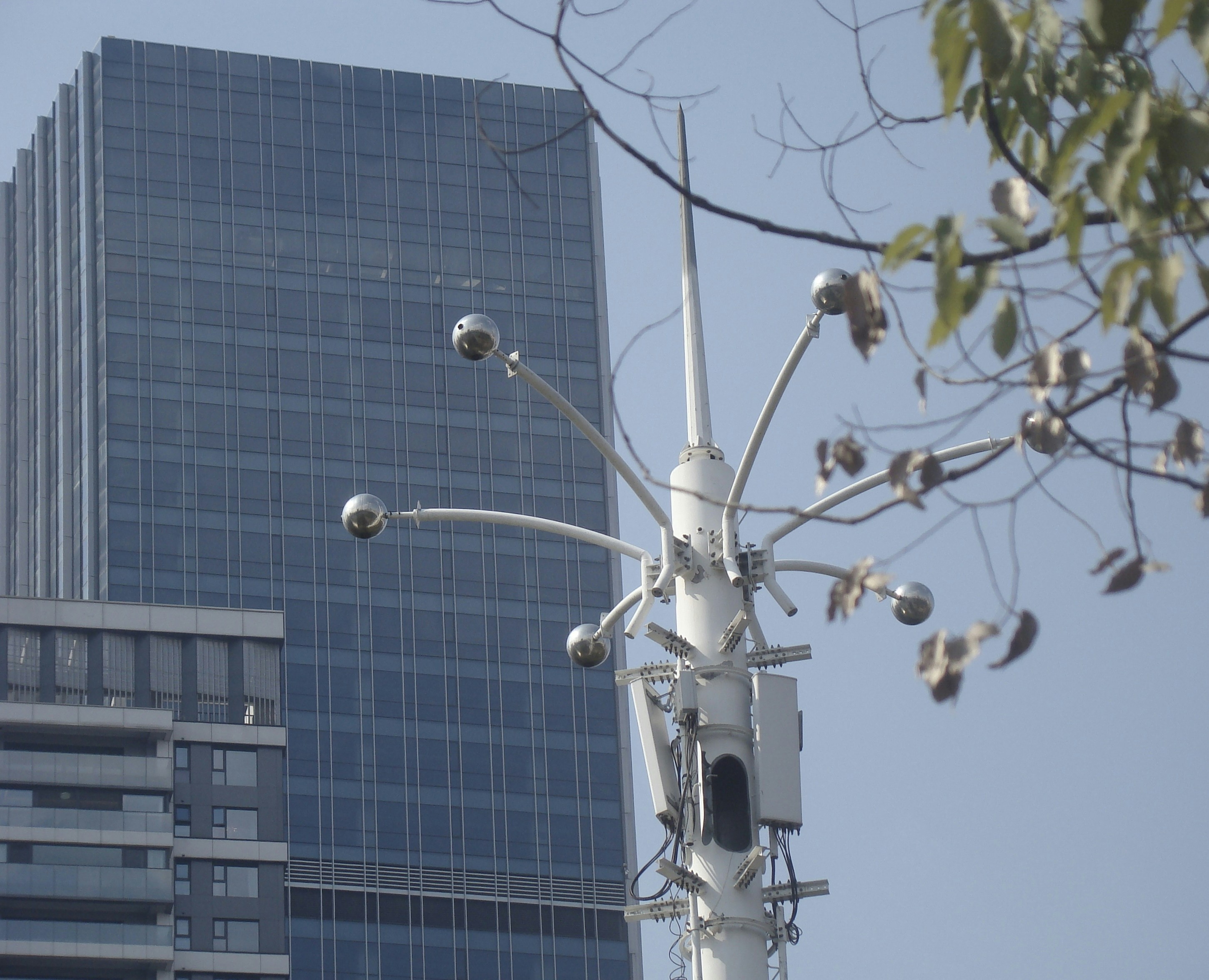 Orbital Arms Against a Glass Canyon: A Futuristic Street Lamp
