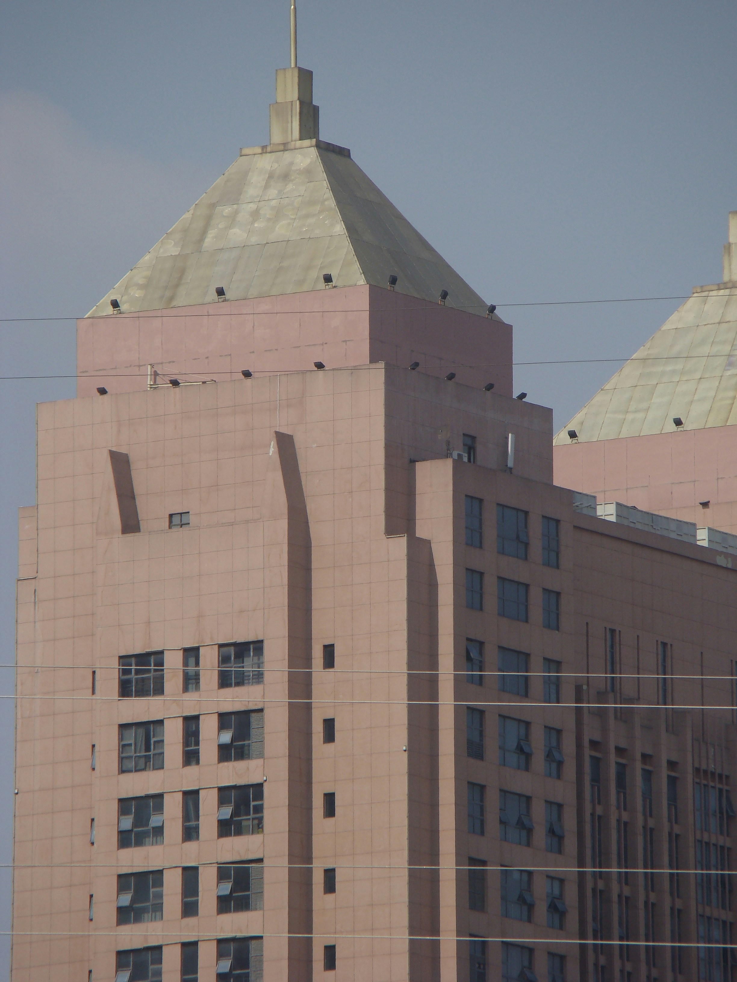 Pink Facade Monolith: Geometric Towers Against a Calm Sky