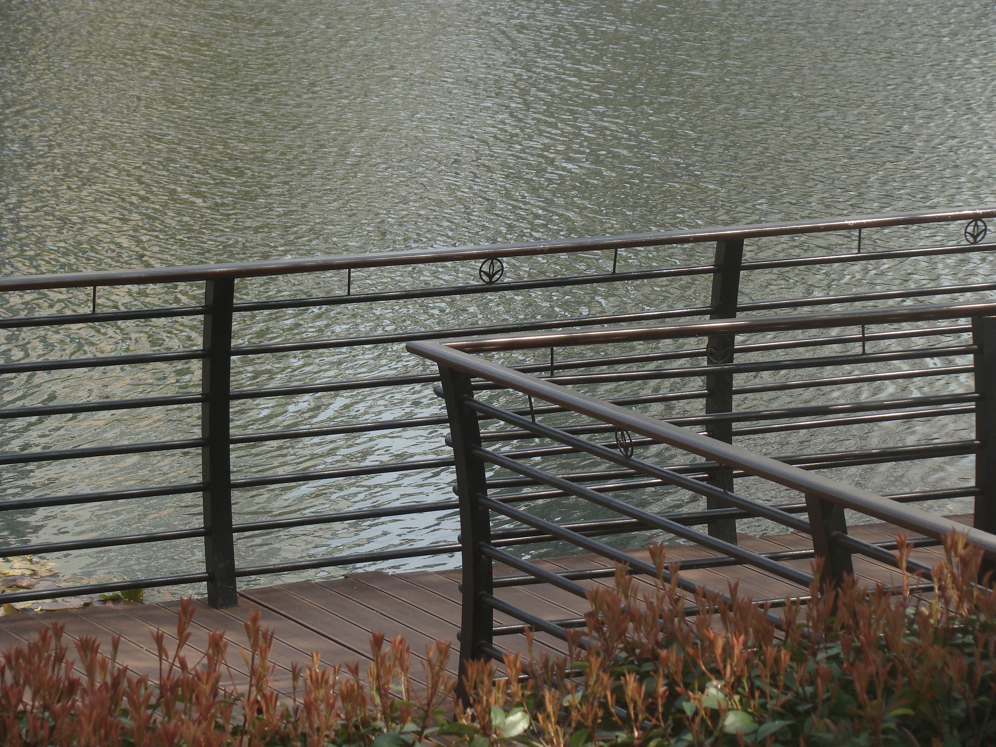 A railing overlooks rippling water. photo – Free Scenery Image on Unsplash