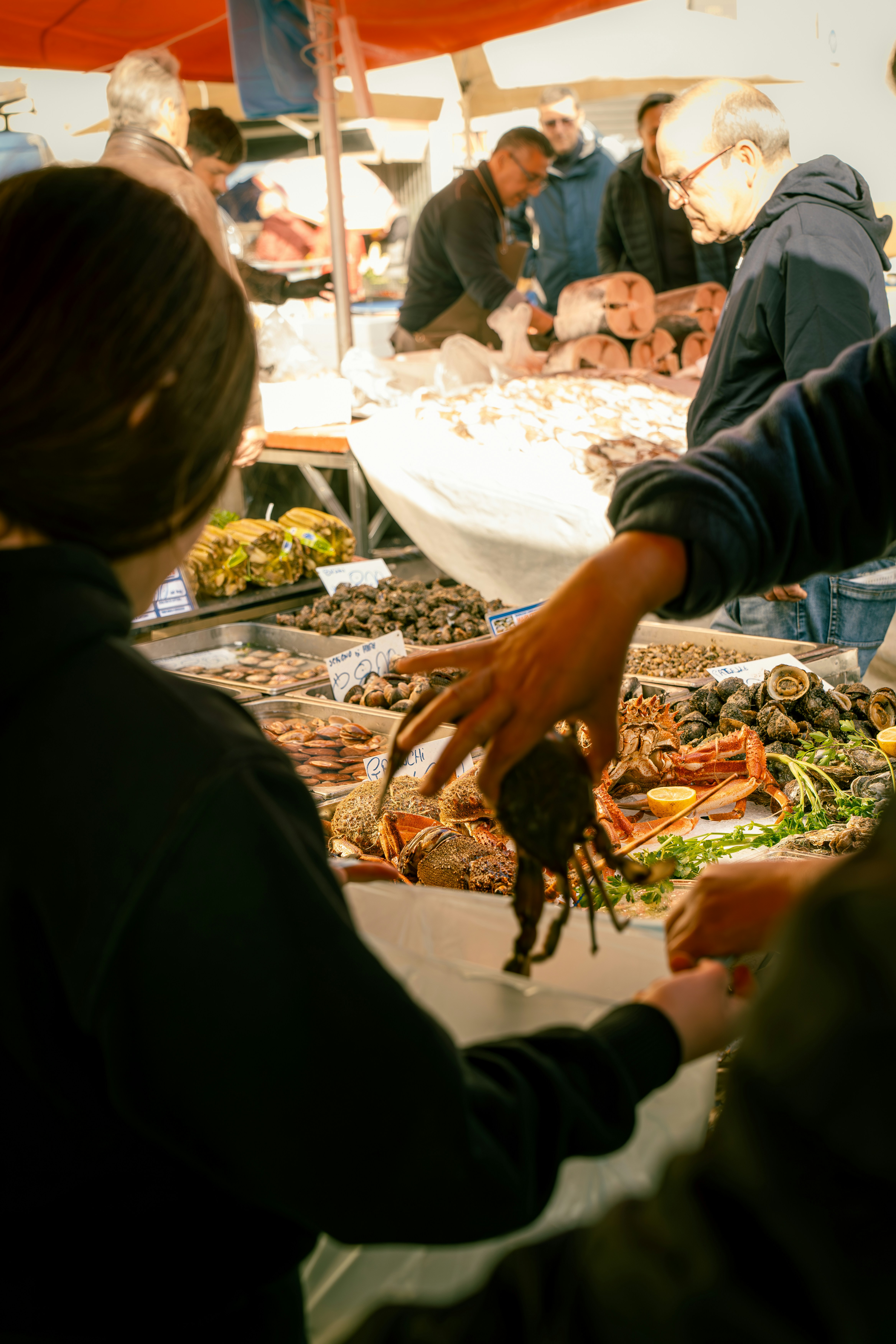 Lobster Handoff at a Bustling Market Seafood Stand
