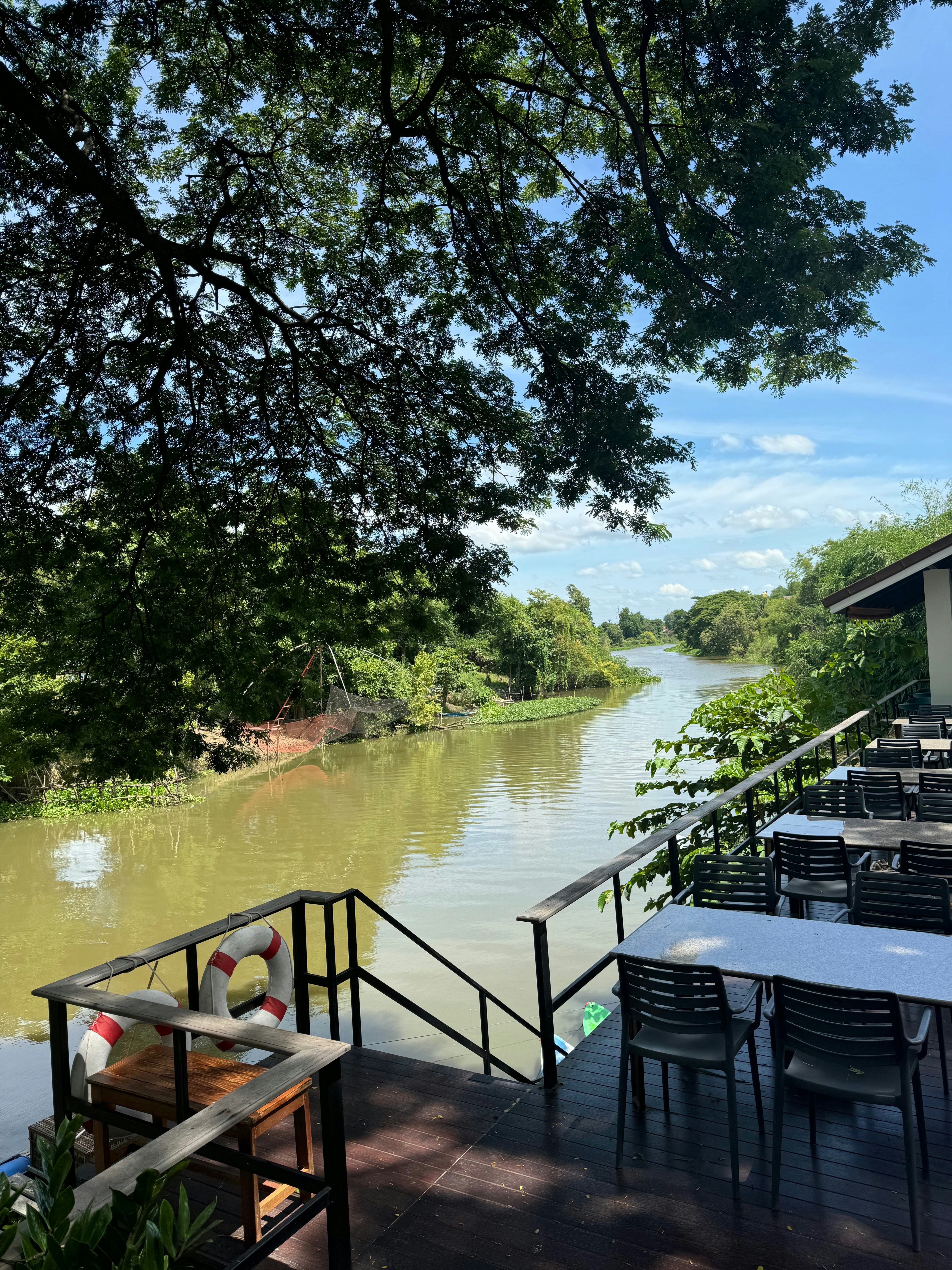 Riverside Café Terrace Framing a Quiet Waterway