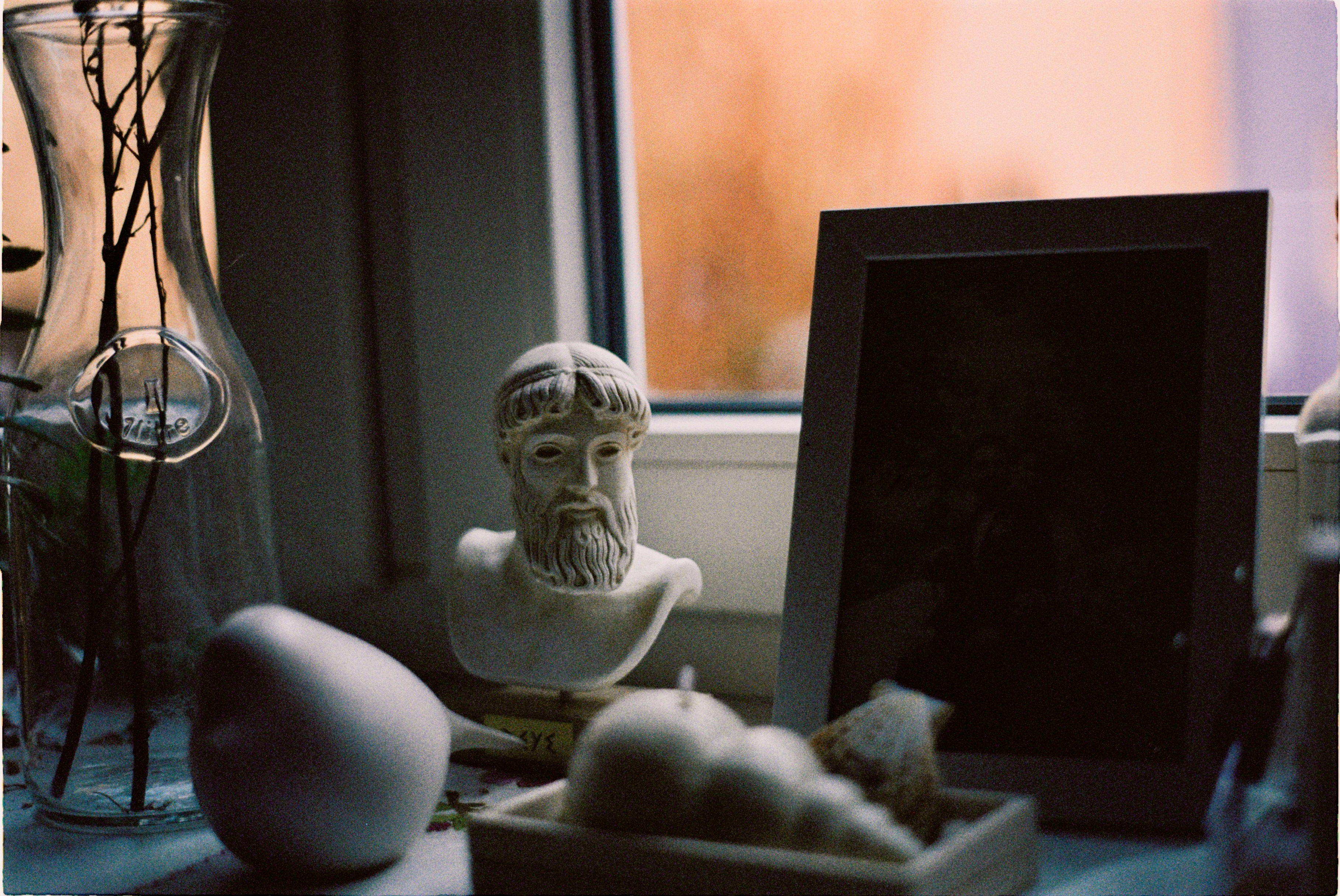 Marble bust under warm window light amid a quiet still-life arrangementHasan Tayyar Besik